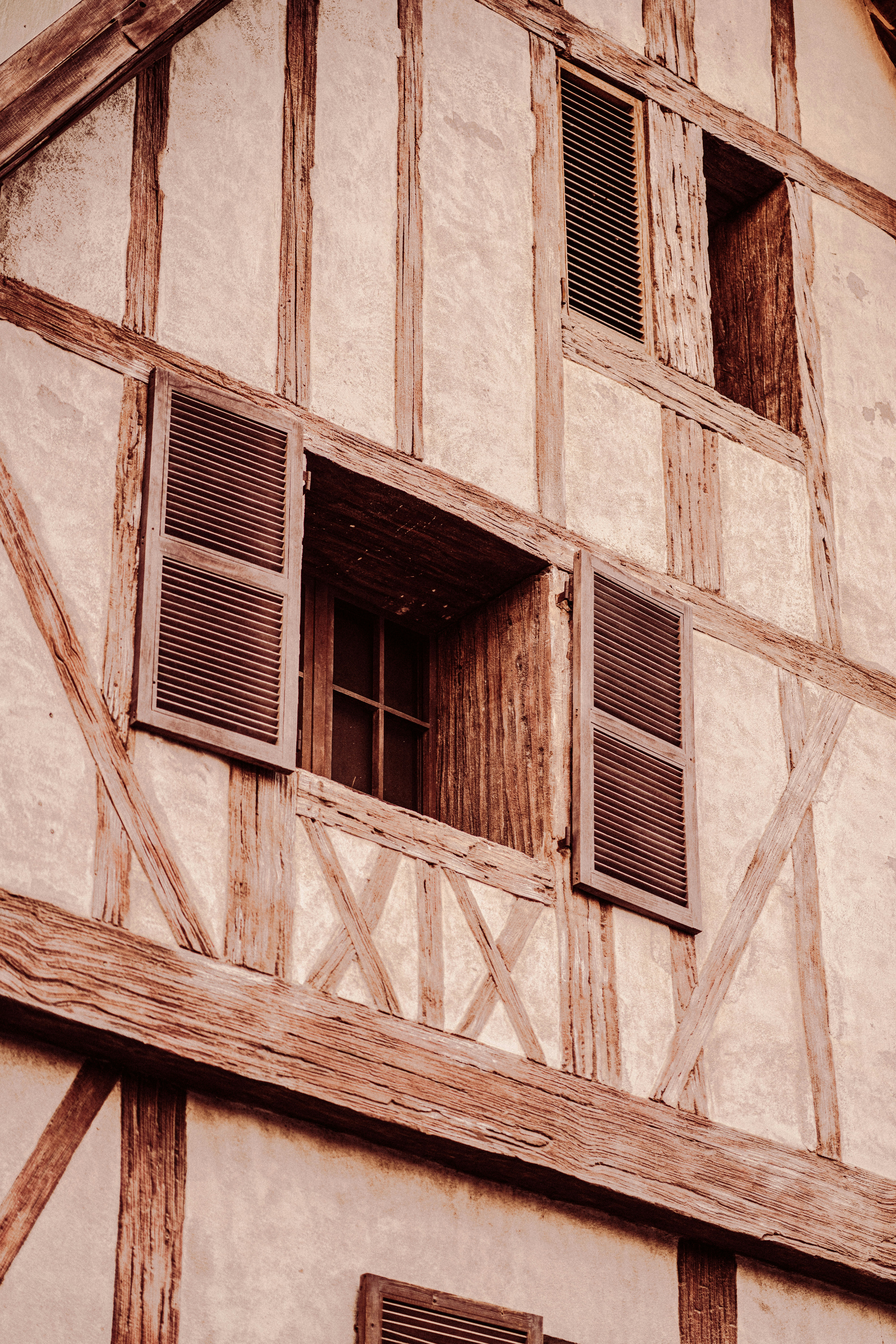Timber-framed façade in dusk light with shuttered windows