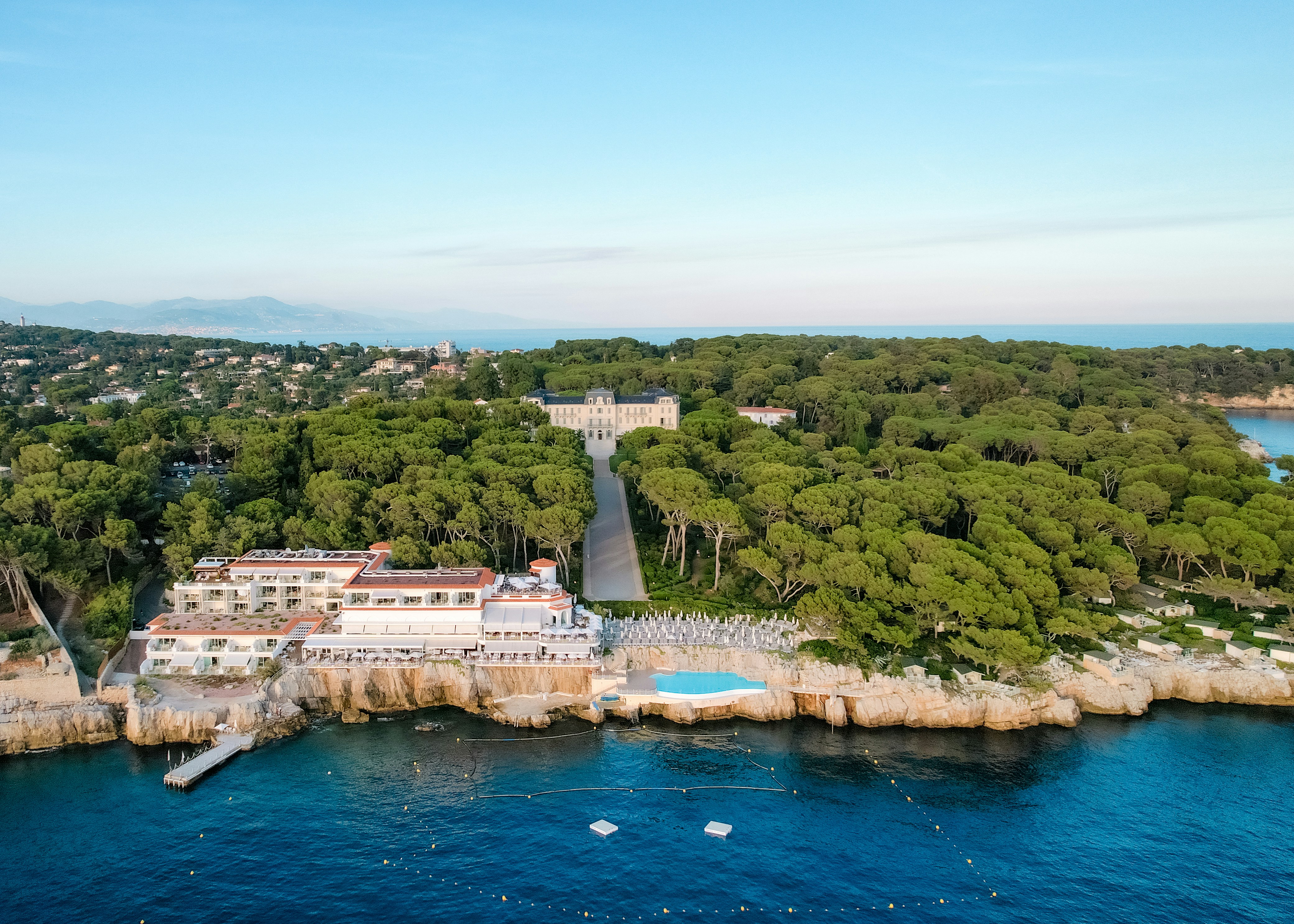 Hotel du Cap-Eden-Roc in Antibes, South of France. | an aerial view of a resort surrounded by trees