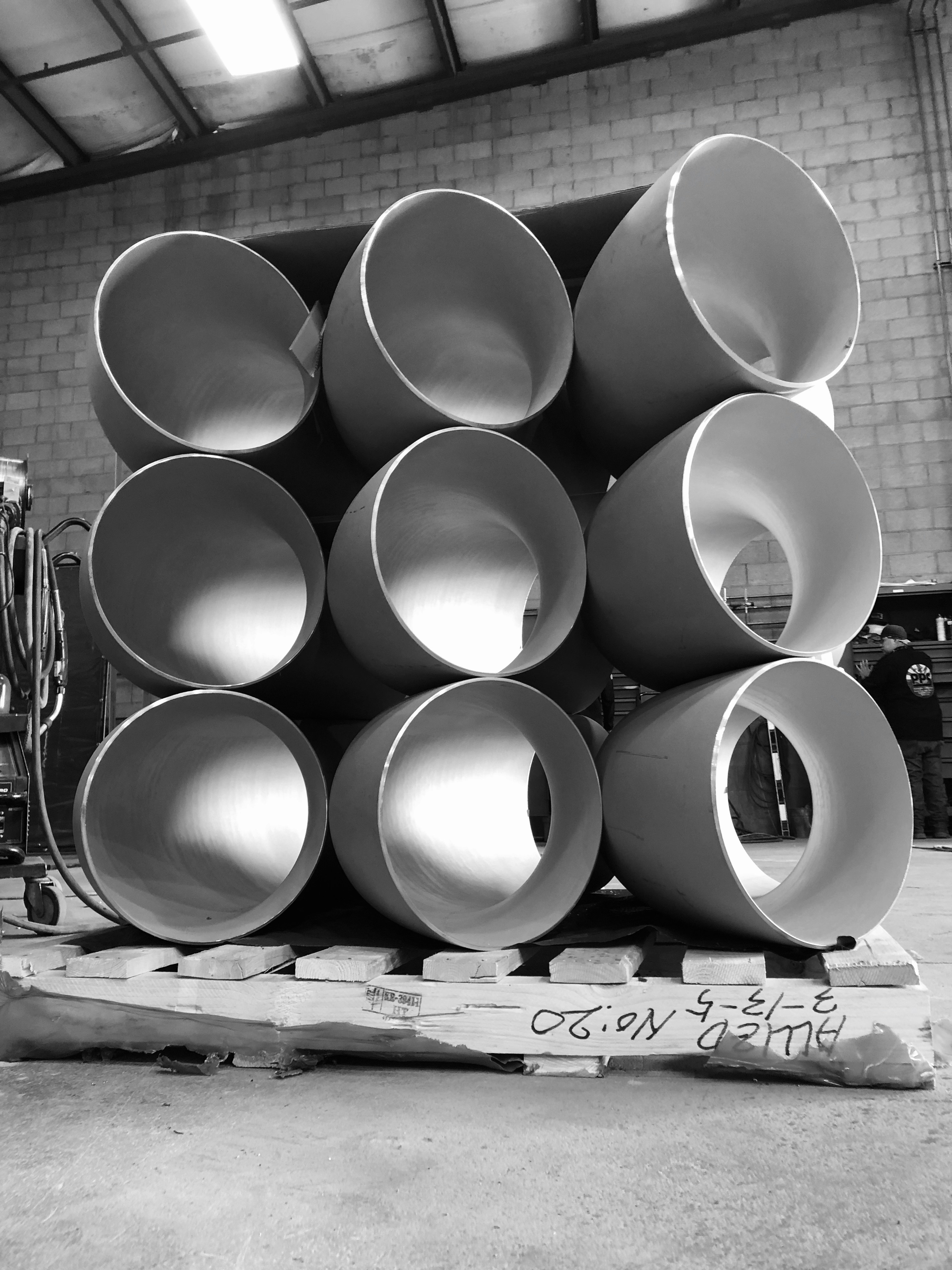 A large stack of steel pipes in a warehouse photo – Free Human Image on ...