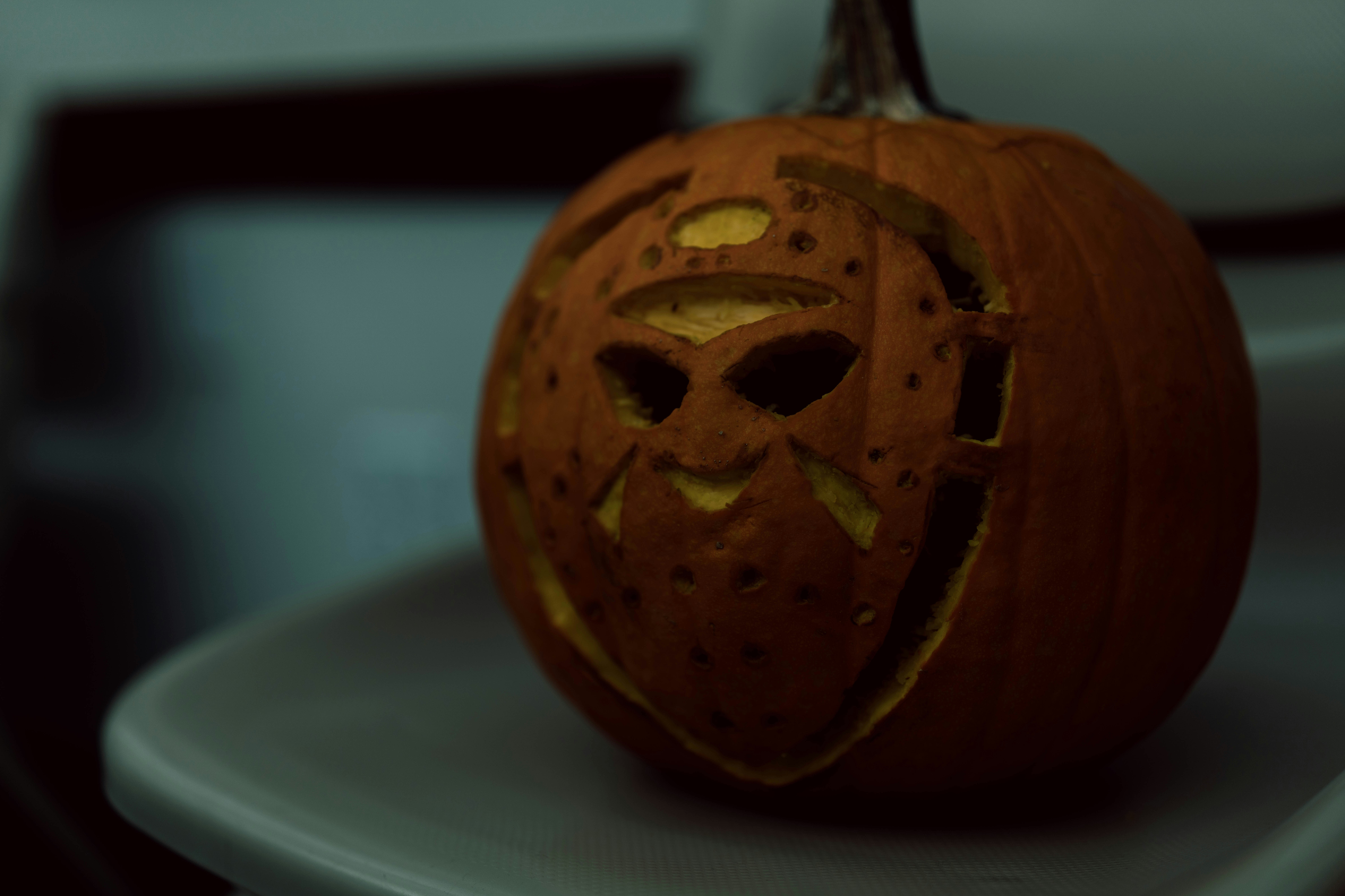 Silent Glow: A Carved Pumpkin on a White Plate