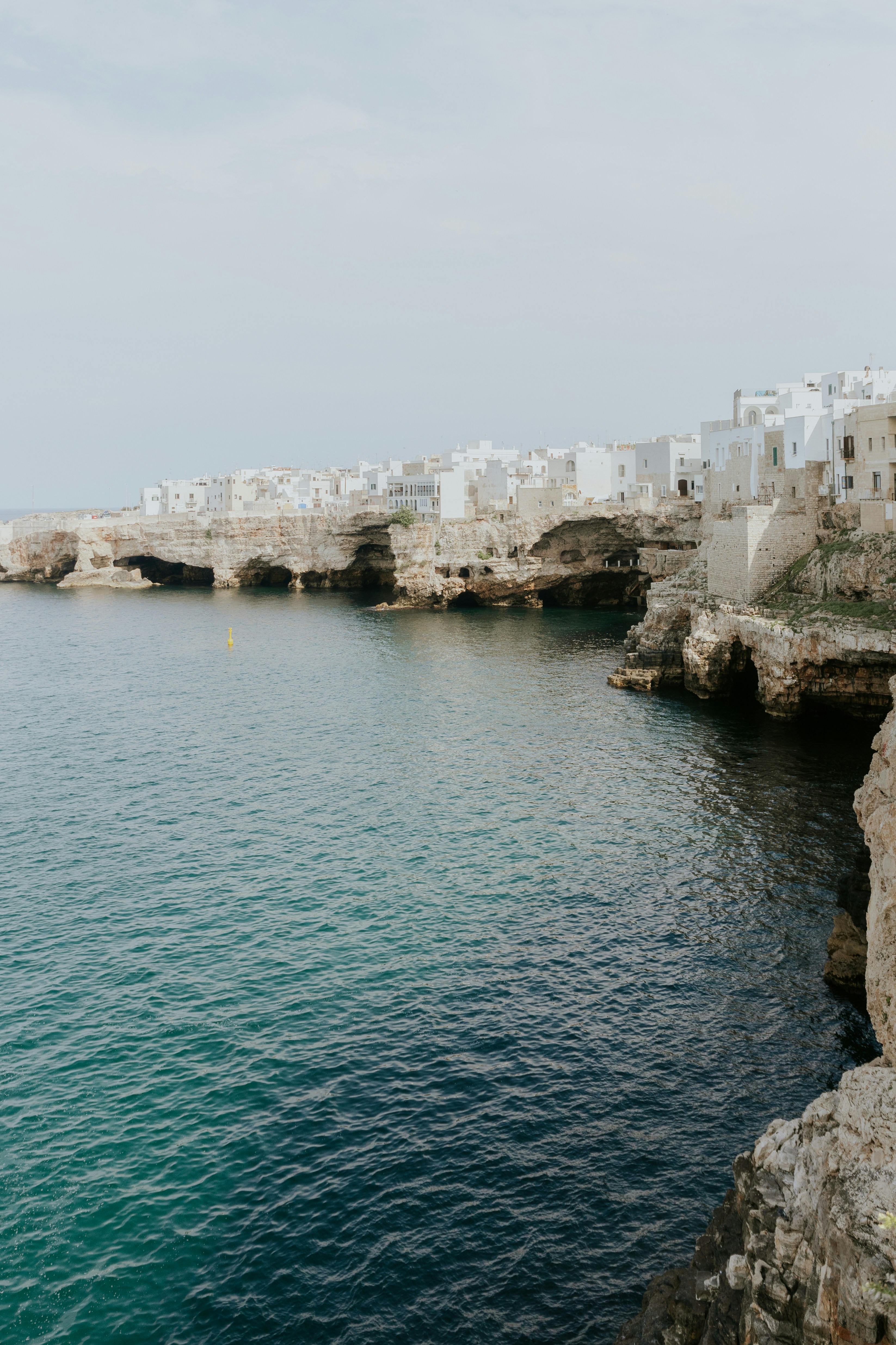 Un plan d’eau à côté d’une falaise rocheuse photo – Photo Polignano a ...