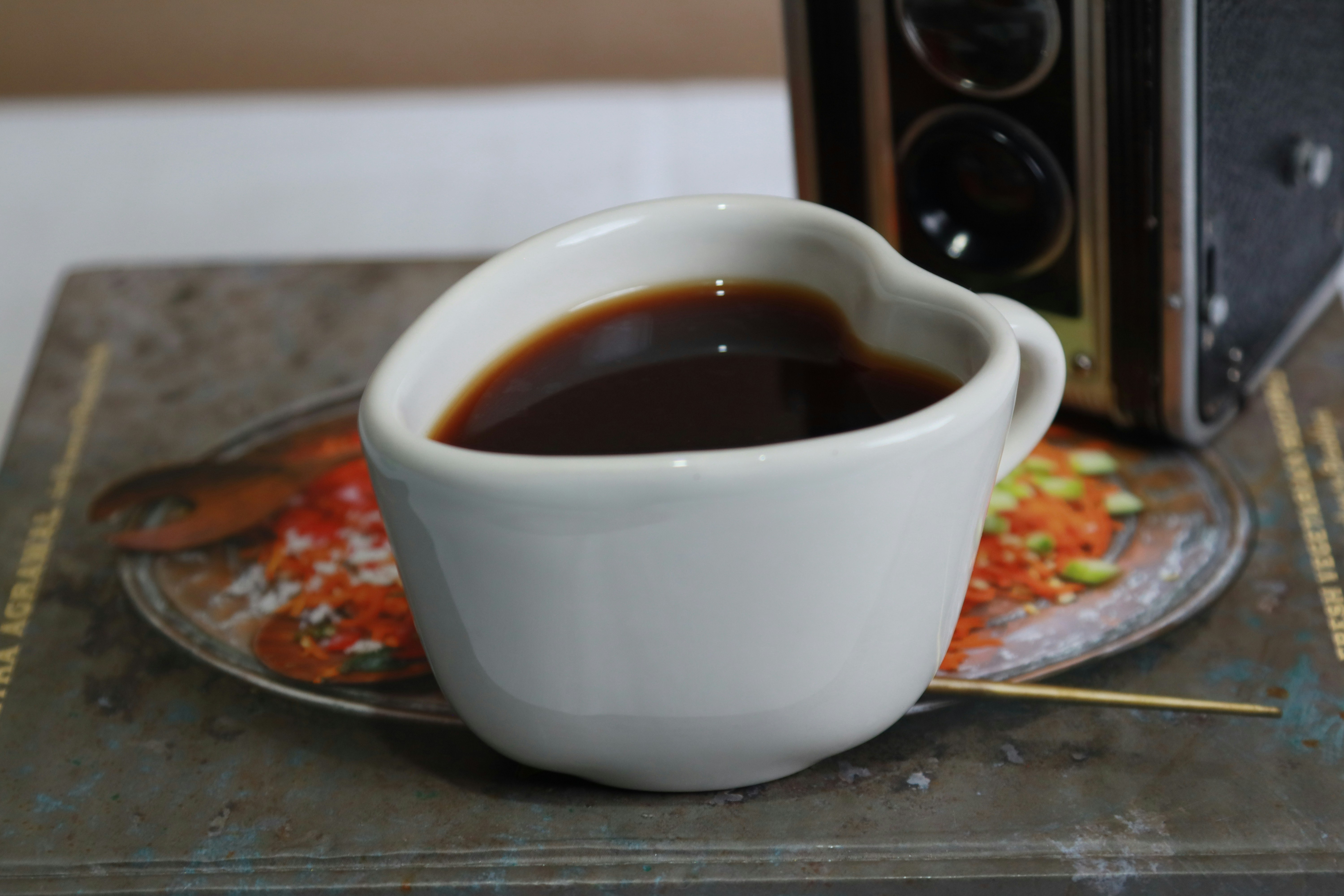 Espresso on the Edge of Memory: A White Cup Framed by a Retro Camera