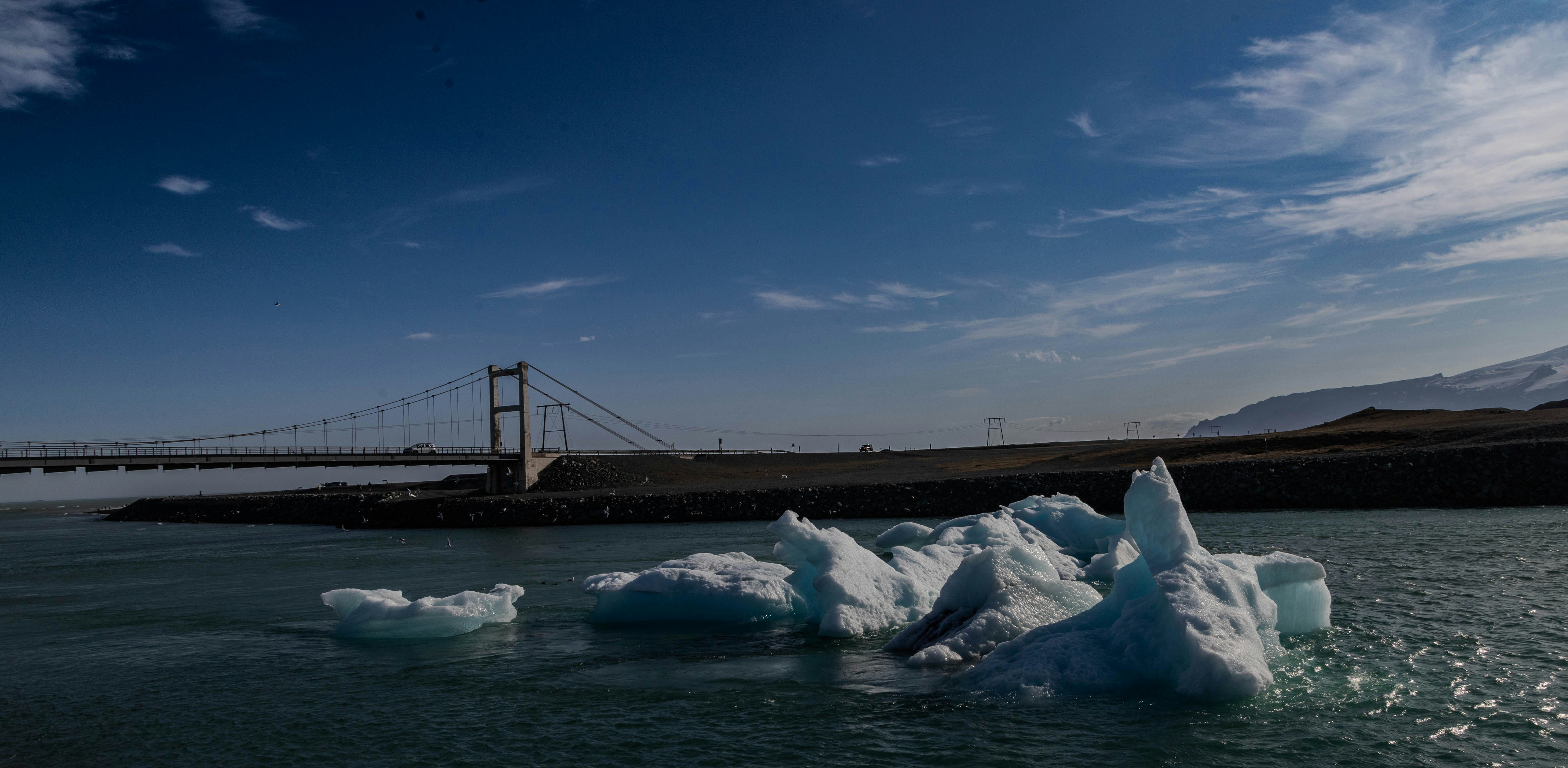 Blue-Ice Echoes: Floating Floes Framed by a Distant Suspension Bridge