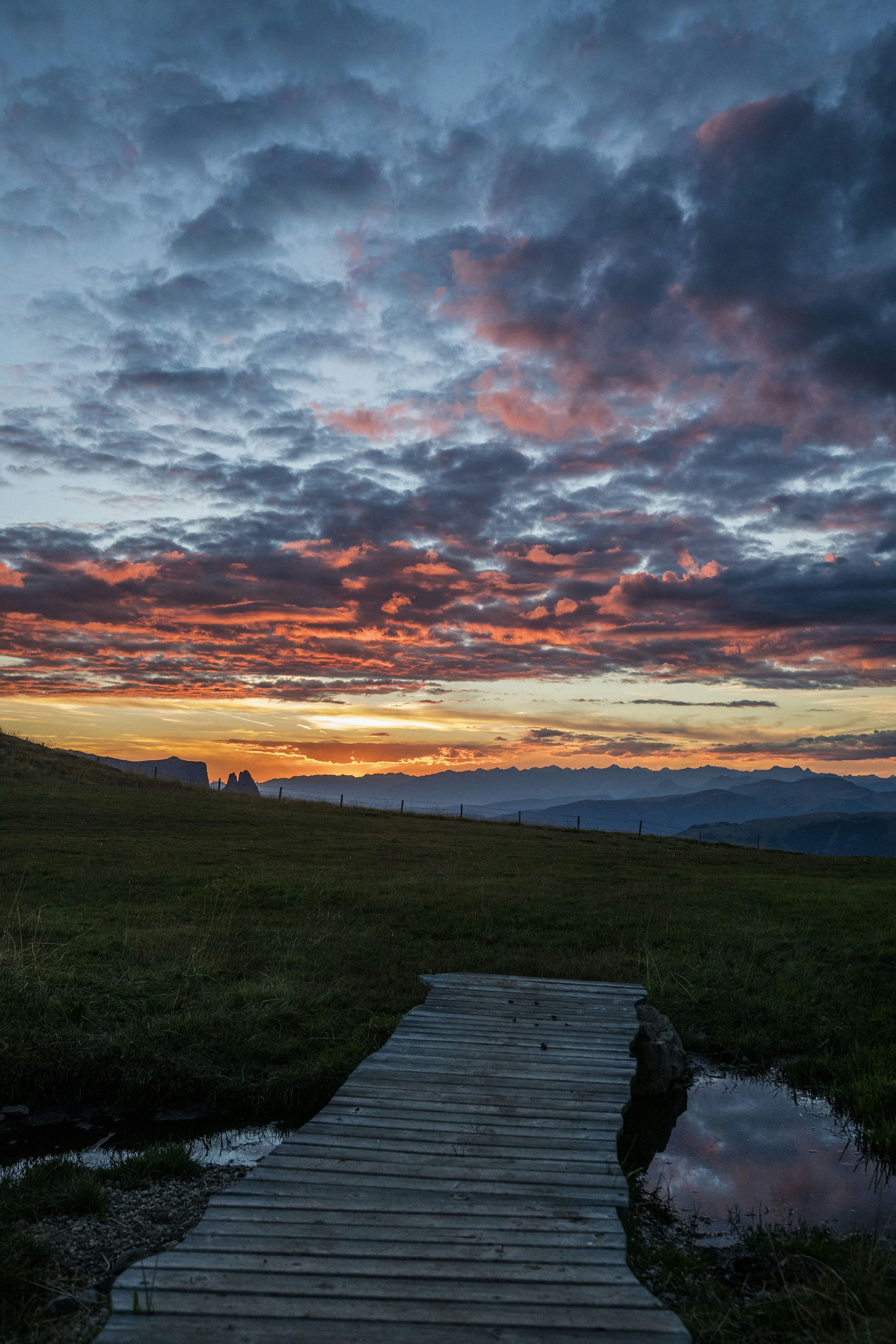 Ember Horizon: Weathered Boardwalk Toward Dusk Over a Mountain Ridge