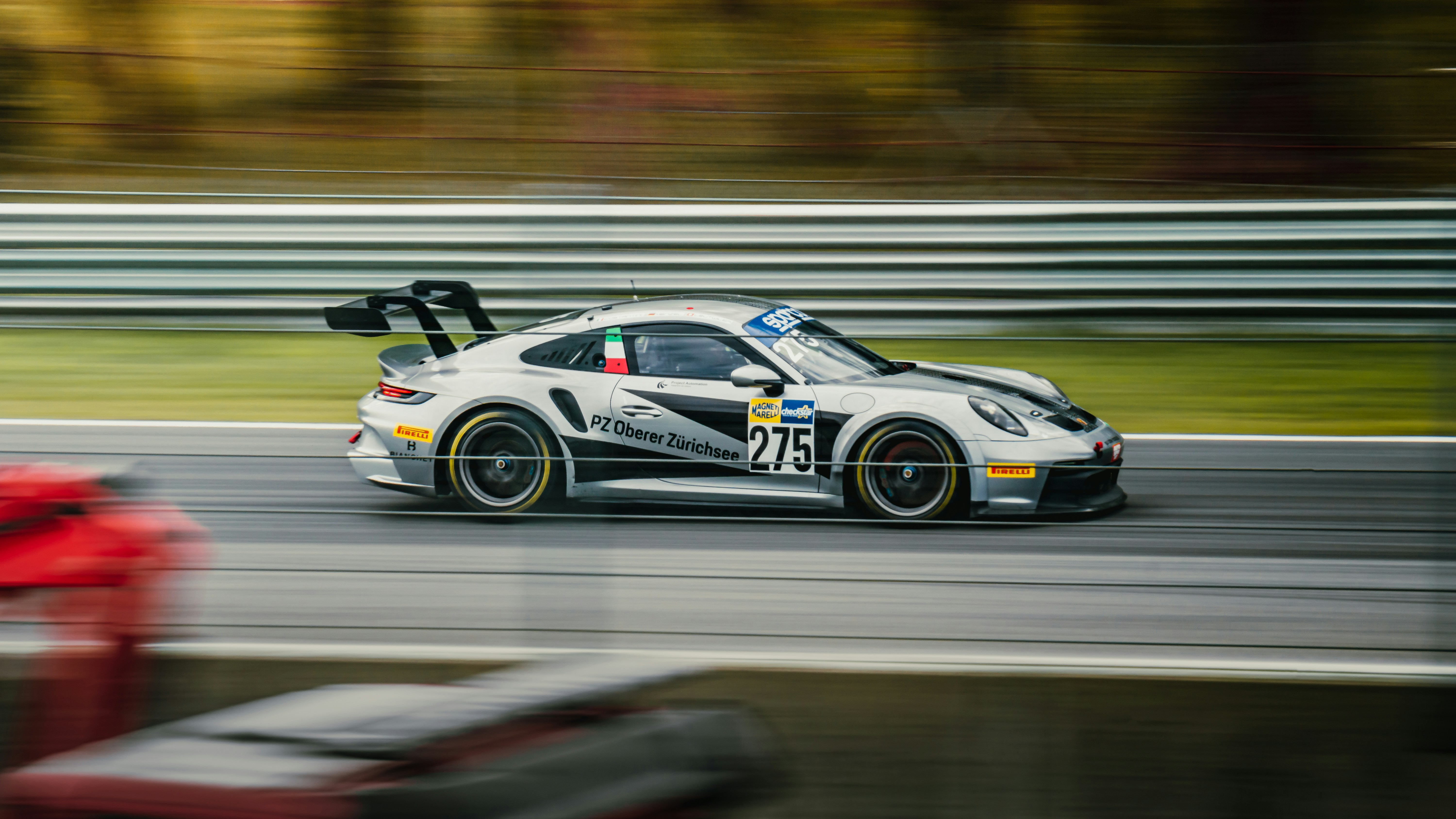 Racing car captured in dynamic motion on a track, showcasing speed and precision.