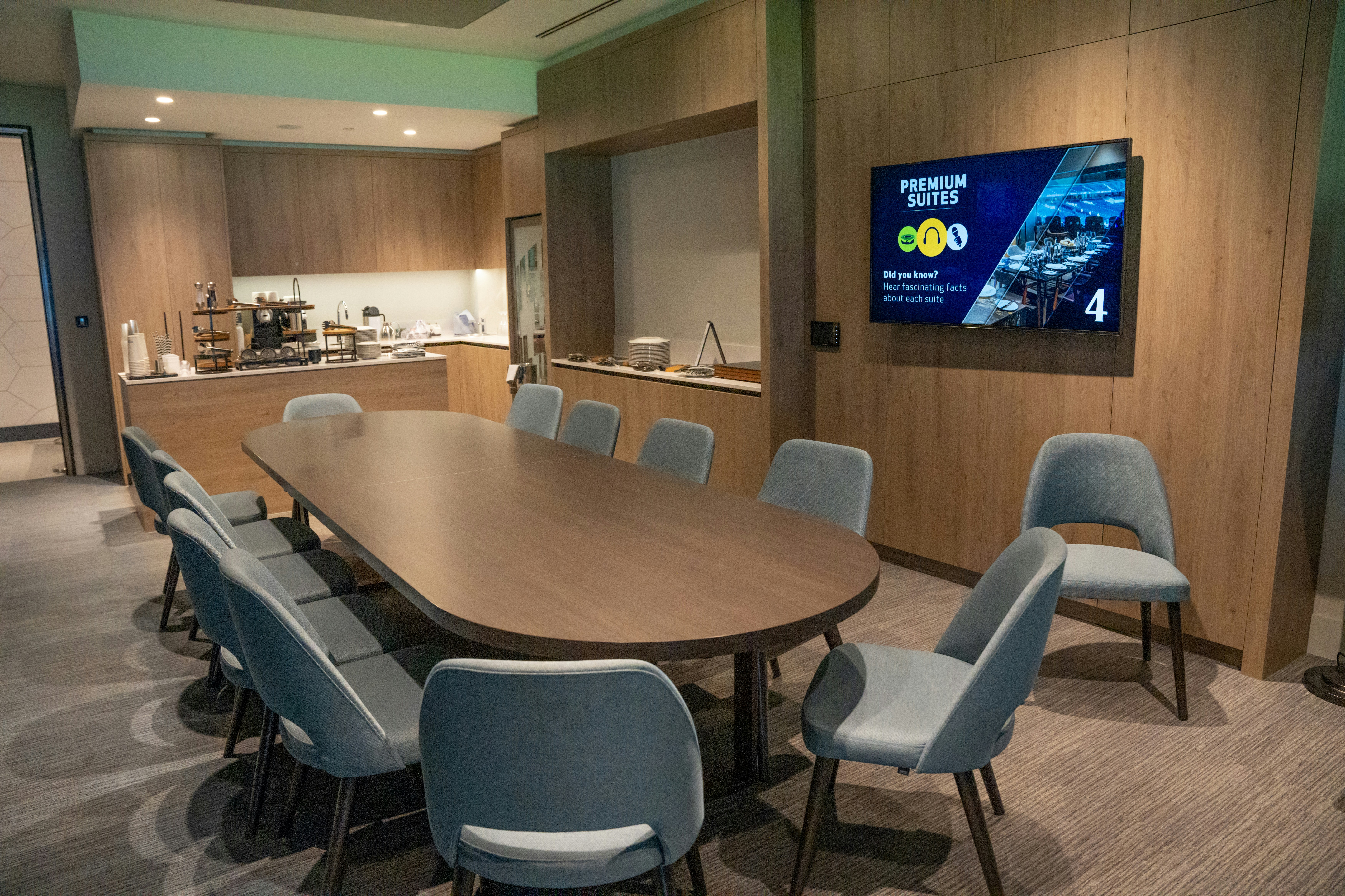 A conference room with a large wooden table and blue chairs photo ...