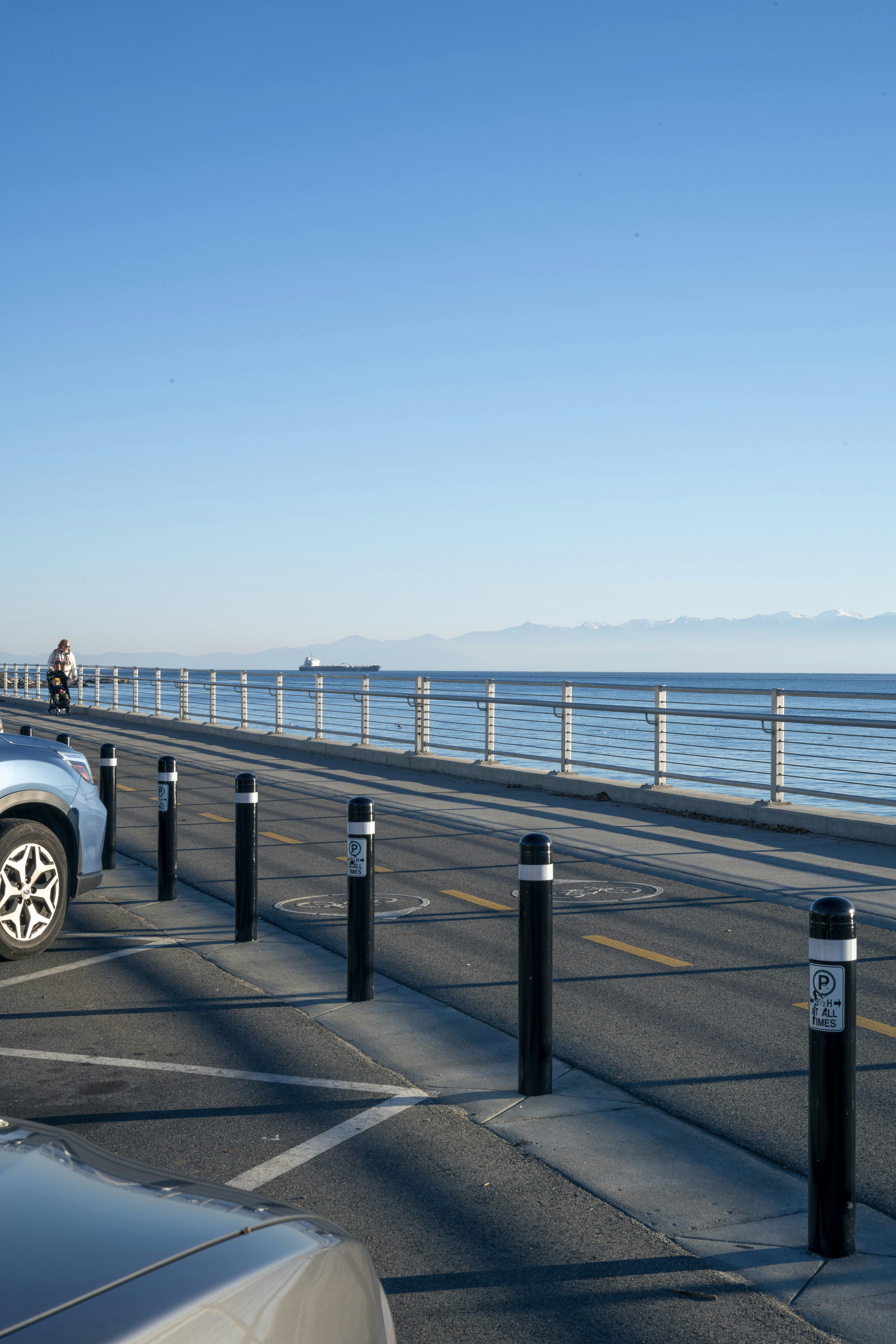 Dawn along the Seafront: Bollards, Rails, and a Wandering Pedestrian