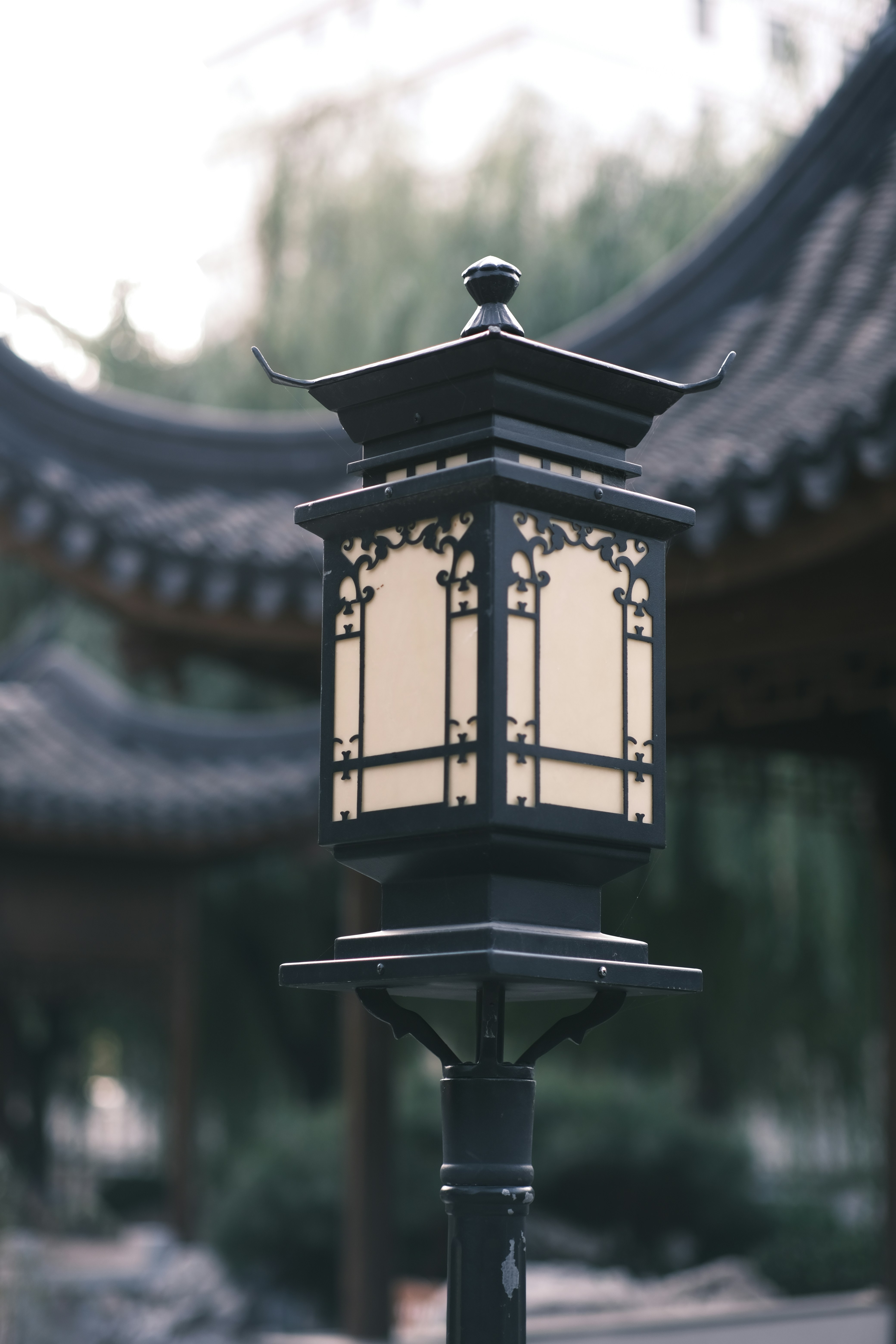 Ornate Lantern on a Quiet Post Before the Temple's Curved Roof