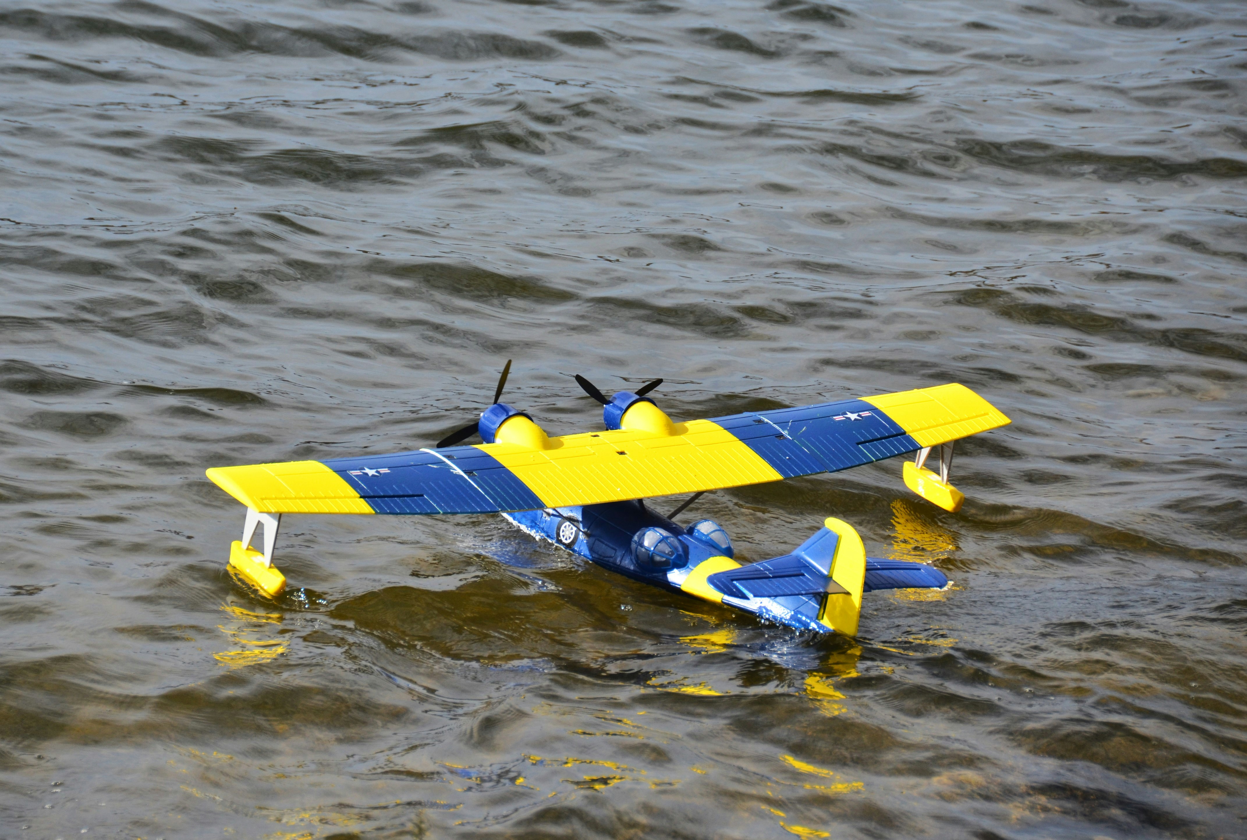 Aerial Play on Water: Yellow-Blue Toy Seaplane Adrift