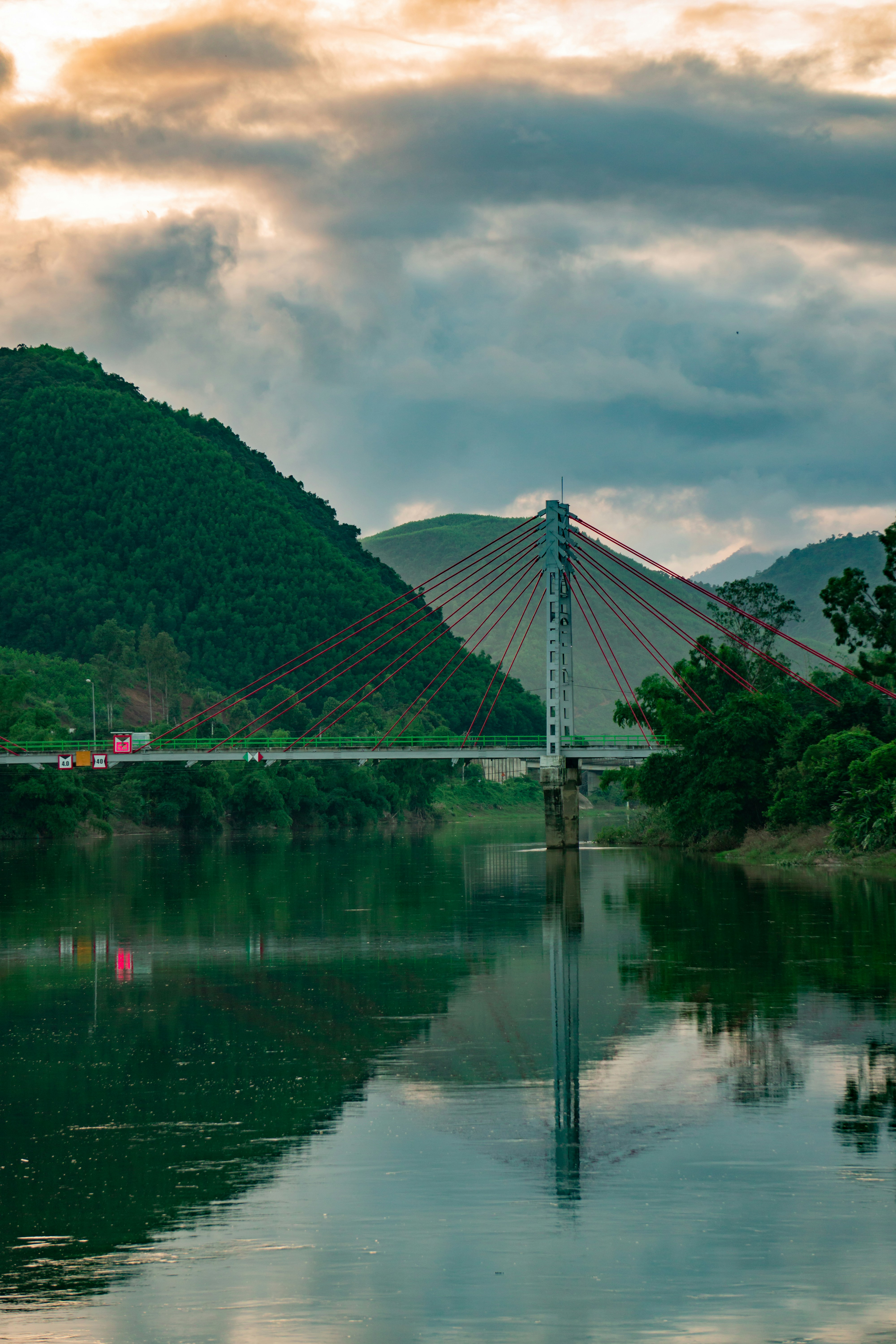 Red Cables and Emerald Valleys: A Quiet Suspension Across a Serene River