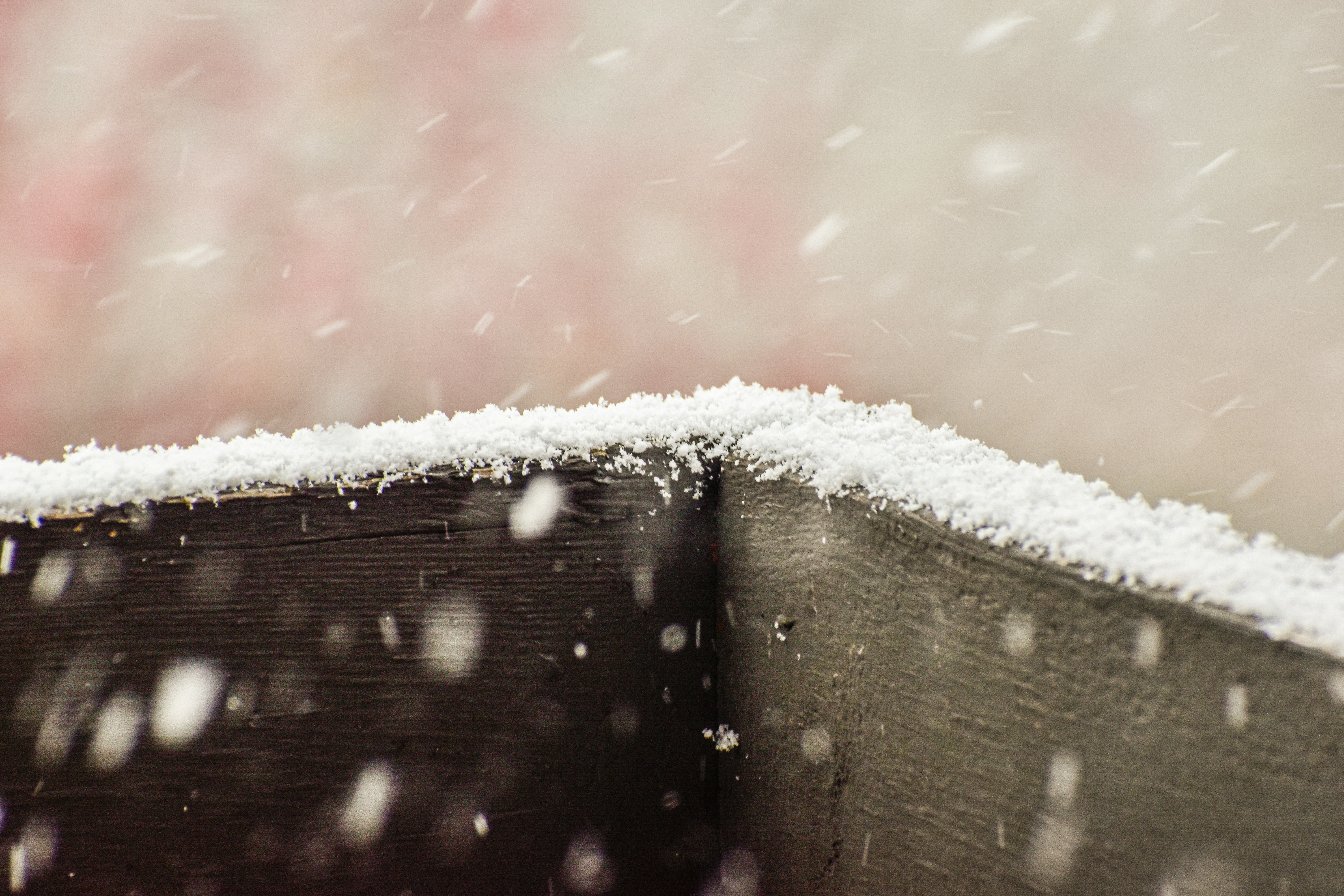 Snow-dusted wooden railing in a winter snowfall