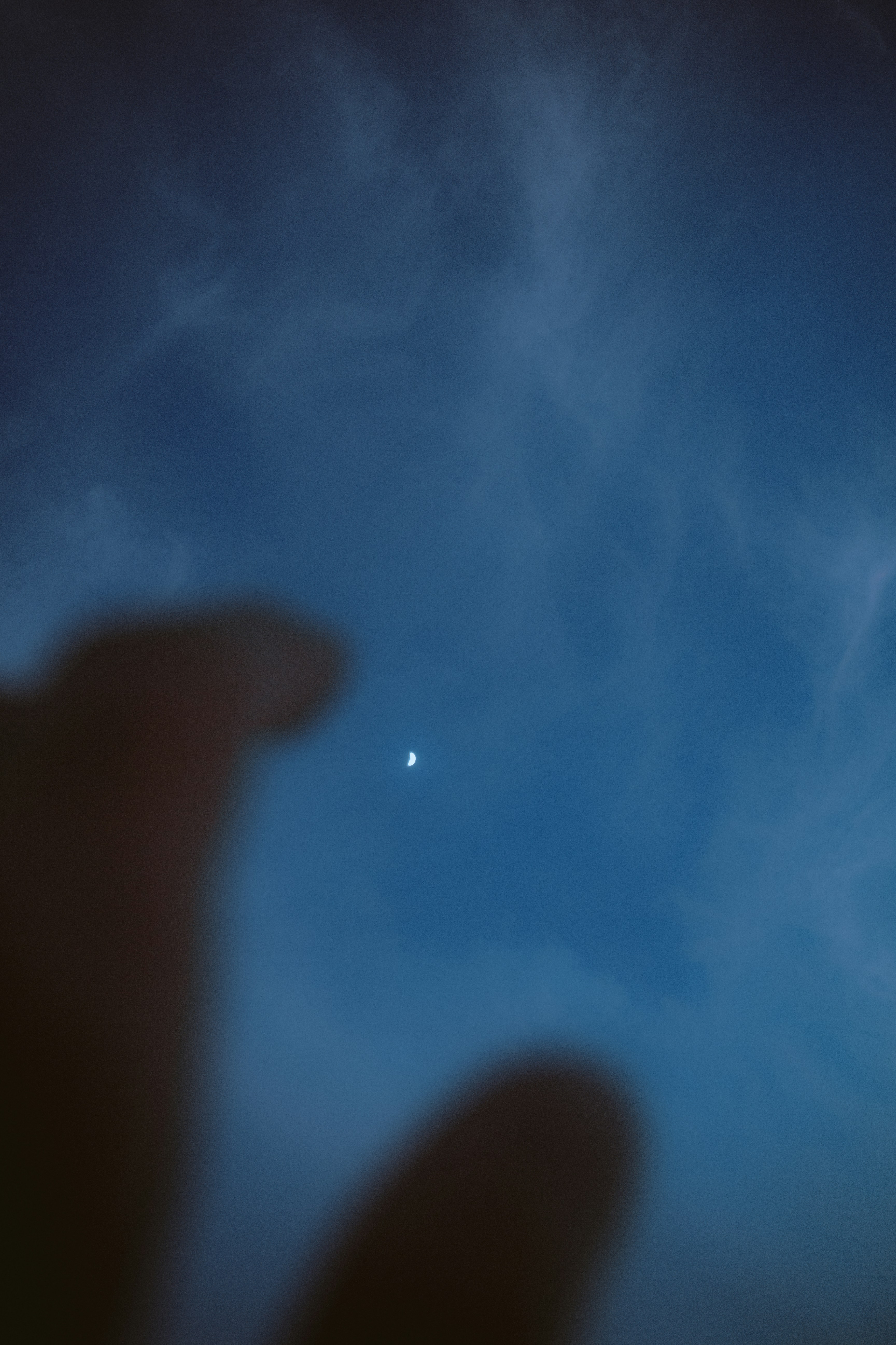 Moonlet in the Cerulean Veil: A Crescent Piercing a Soft Foreground Blur