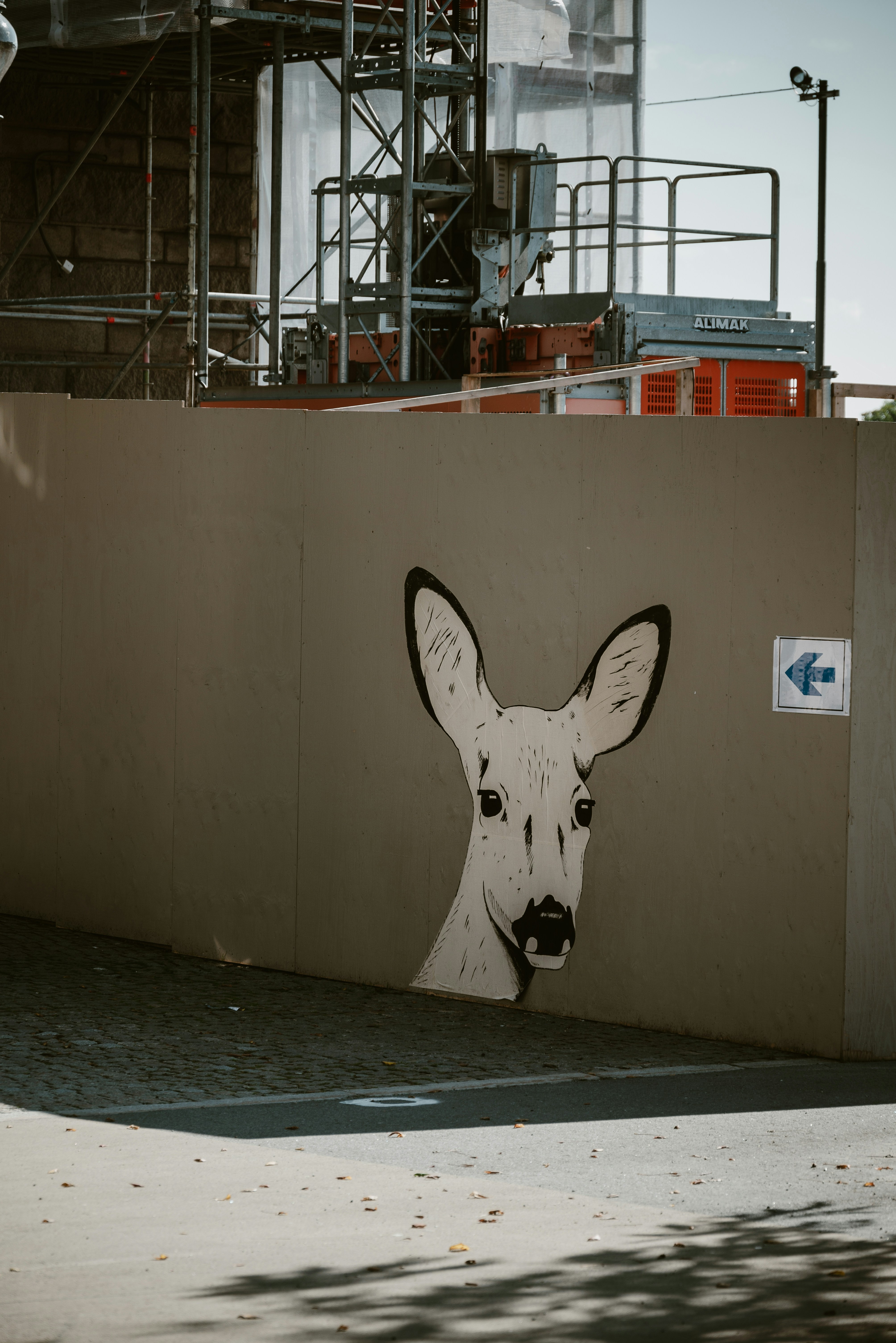 Deer Portrait on a Construction Barrier Amid Industrial Scaffolding