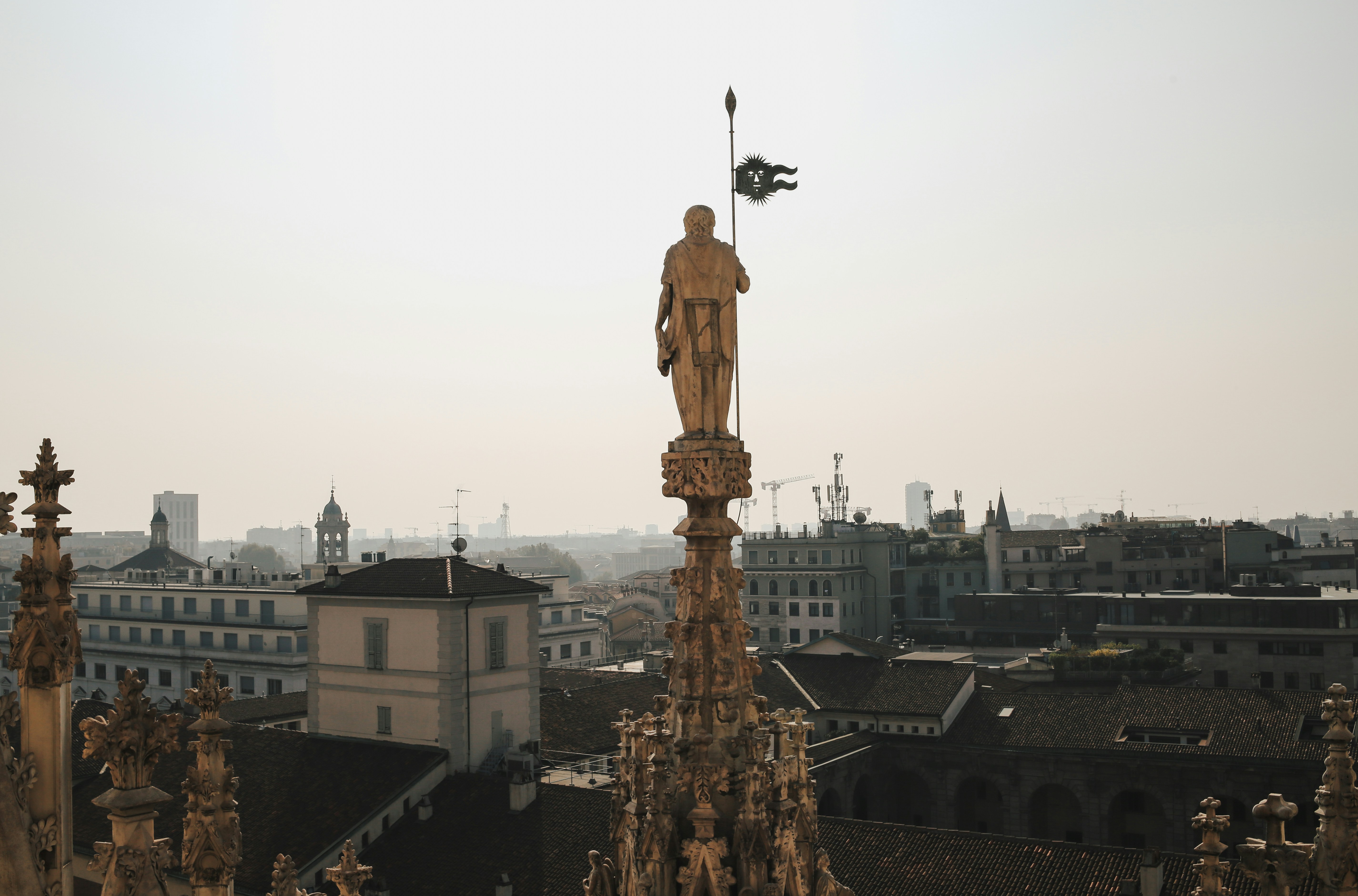 The Watcher on the Spire: A Golden Figure Guarding a Sunlit Rooftop City