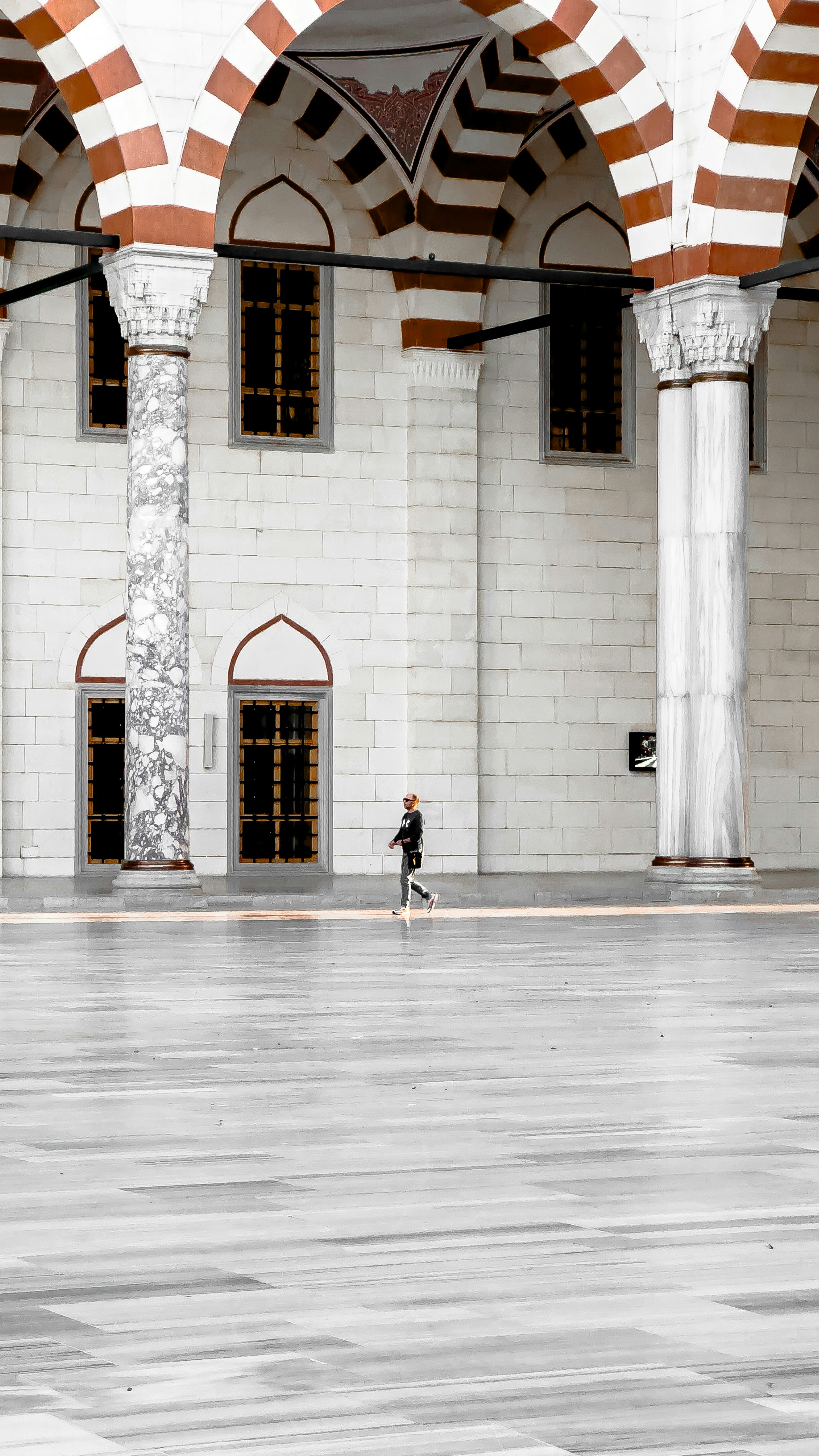 Solitary Stride Under the Striped Marble Colonnade