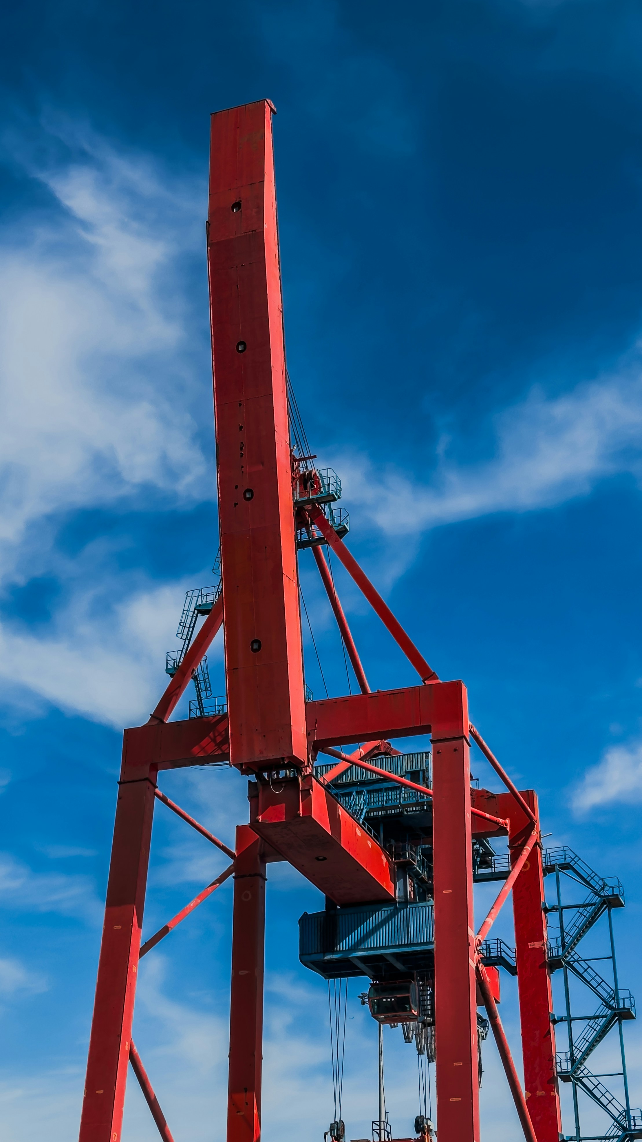 Crimson Girder Rising: A Red Crane Against a Sharp Blue Sky