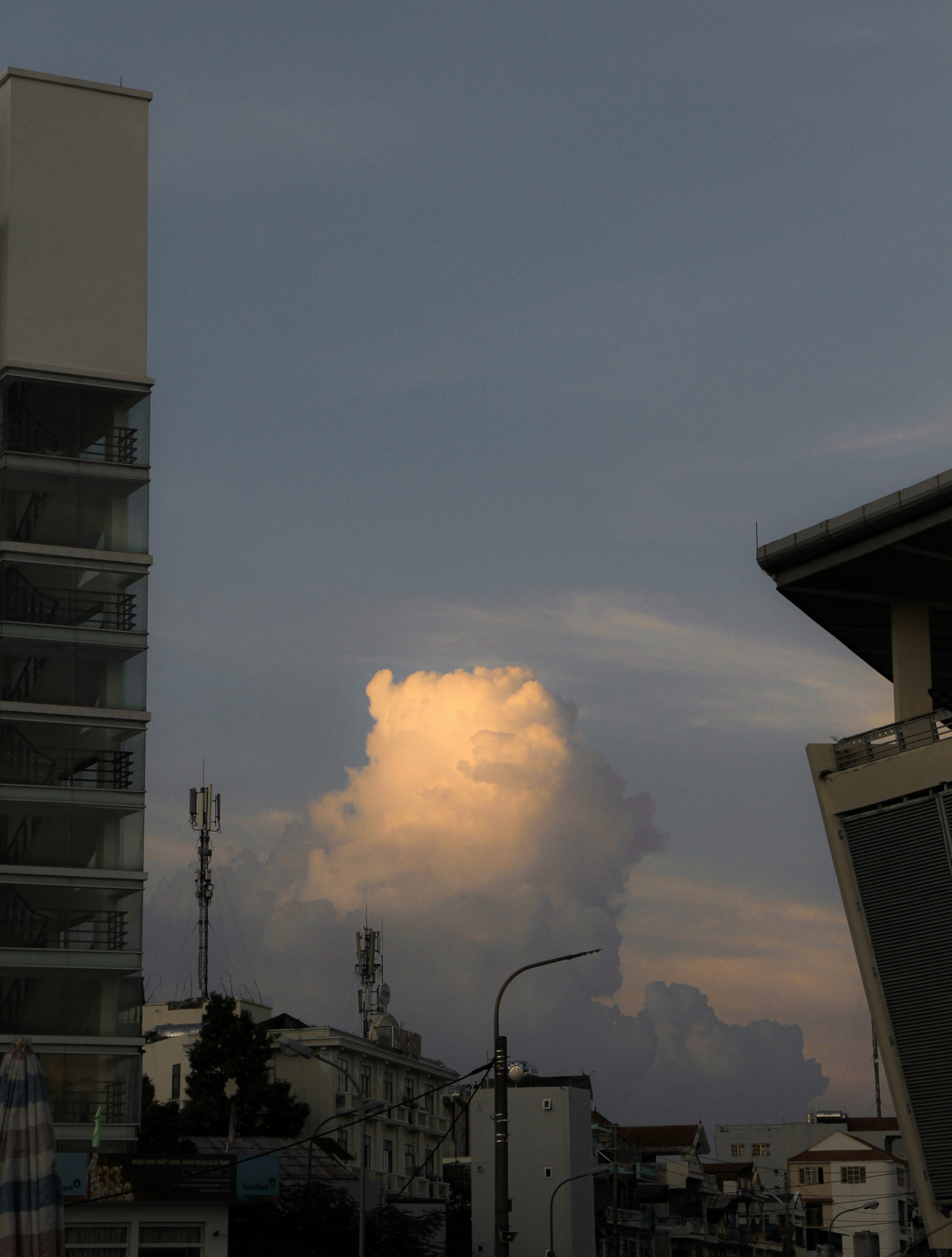 Sunlit Cumulus Over a Quiet Cityscape at Dusk