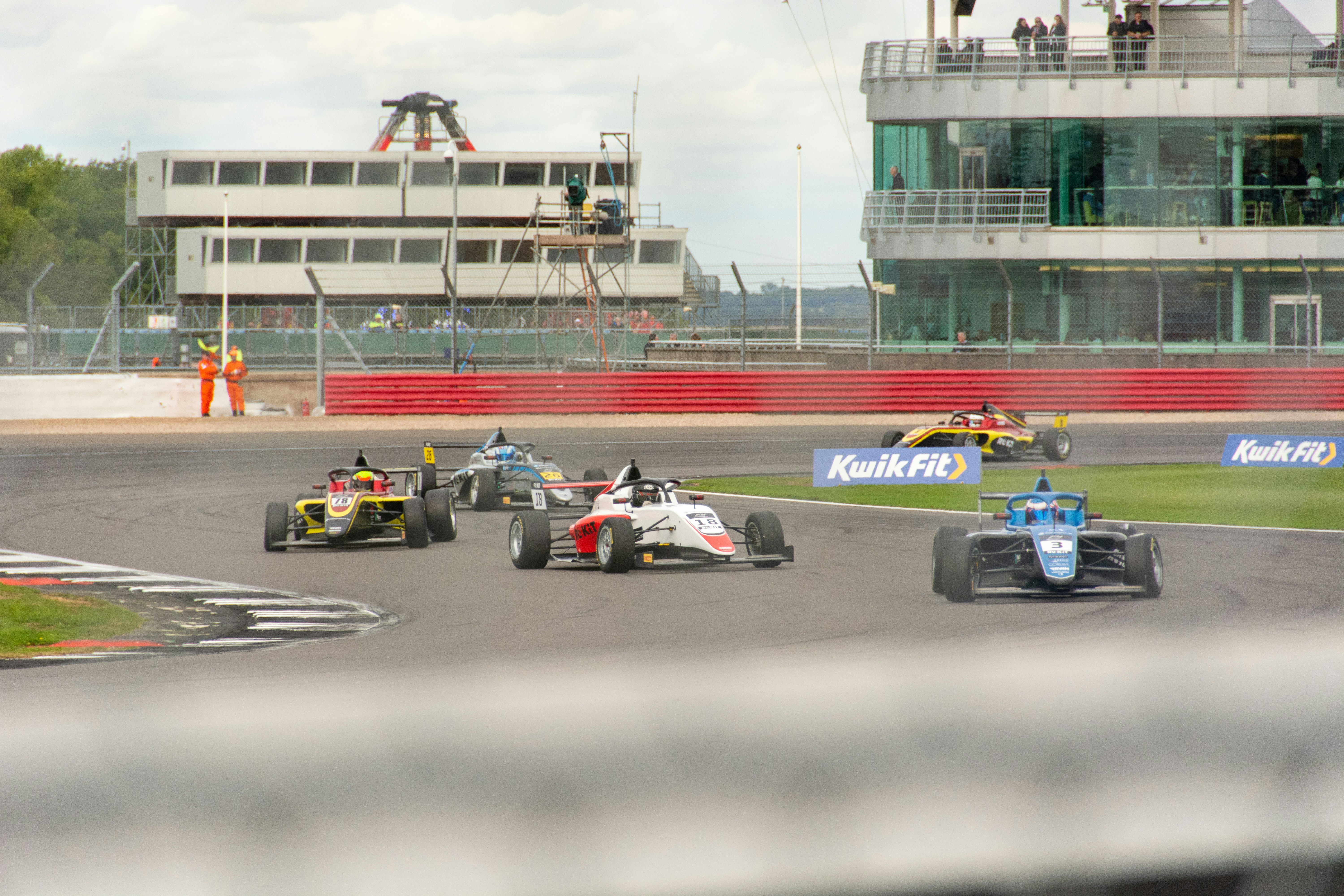 A group of racing cars driving down a race track photo – Free ...
