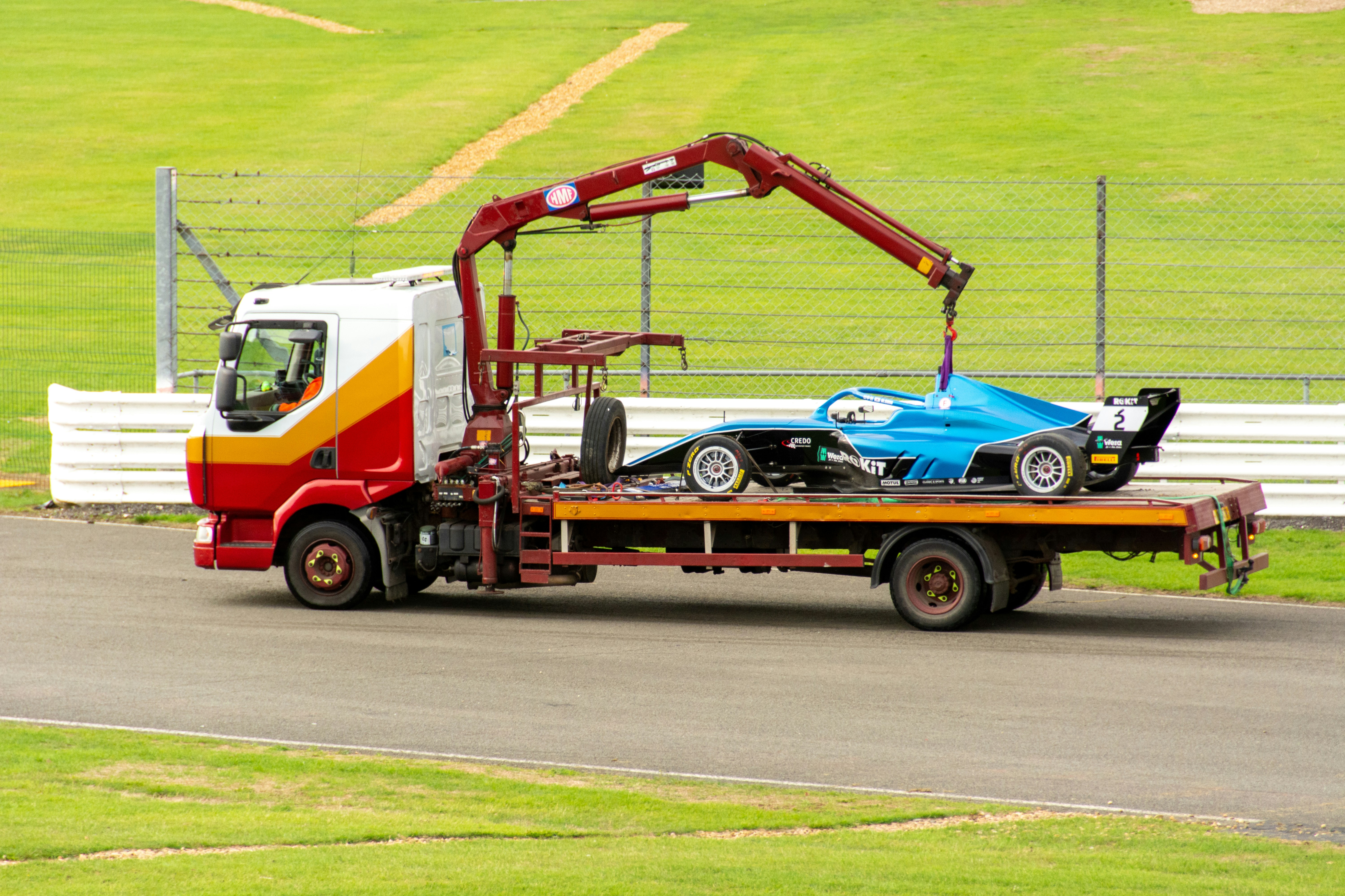 A tow truck with a car on the back of it photo – Free Silverstone ...
