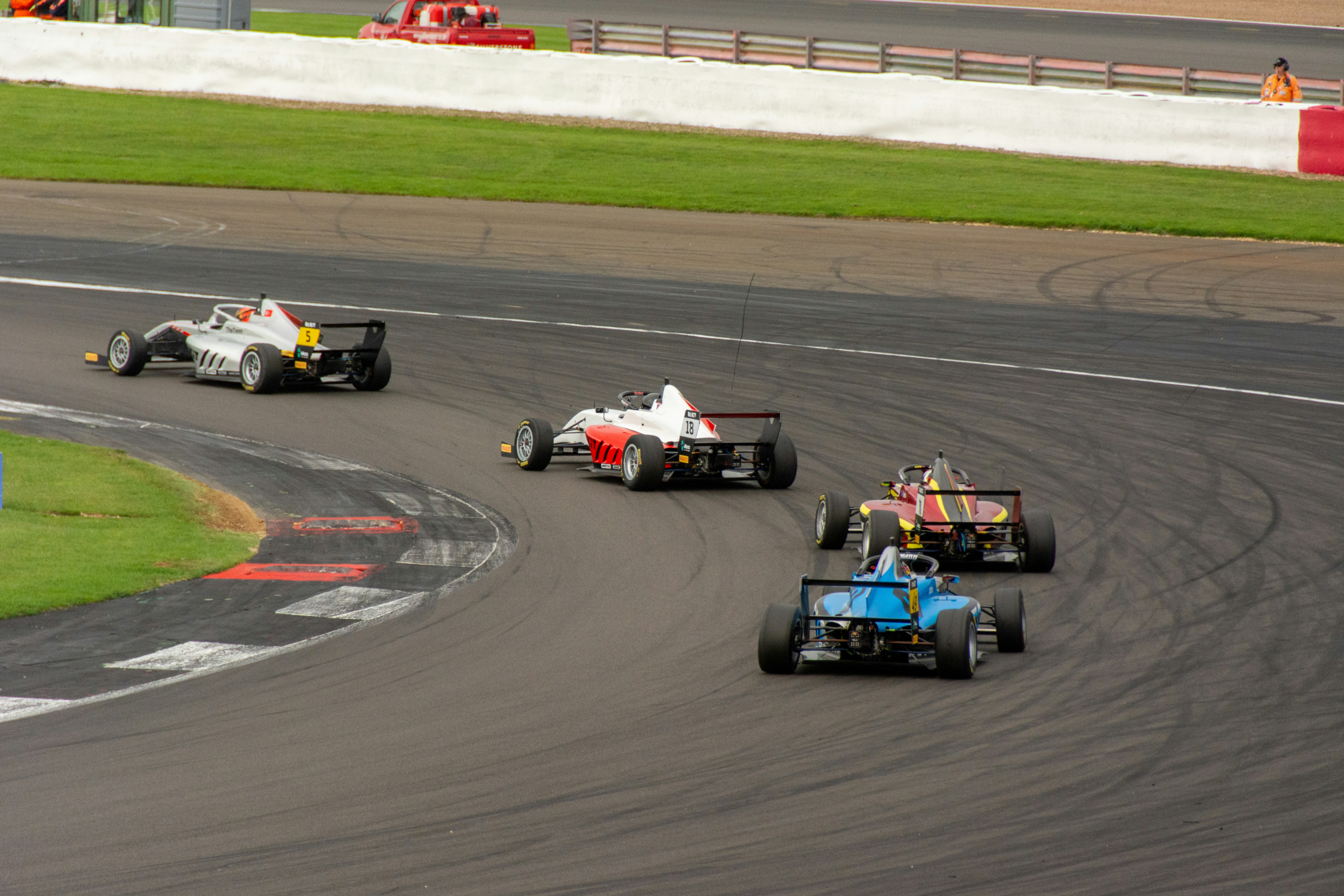 A group of racing cars driving around a track photo – Free Silverstone ...