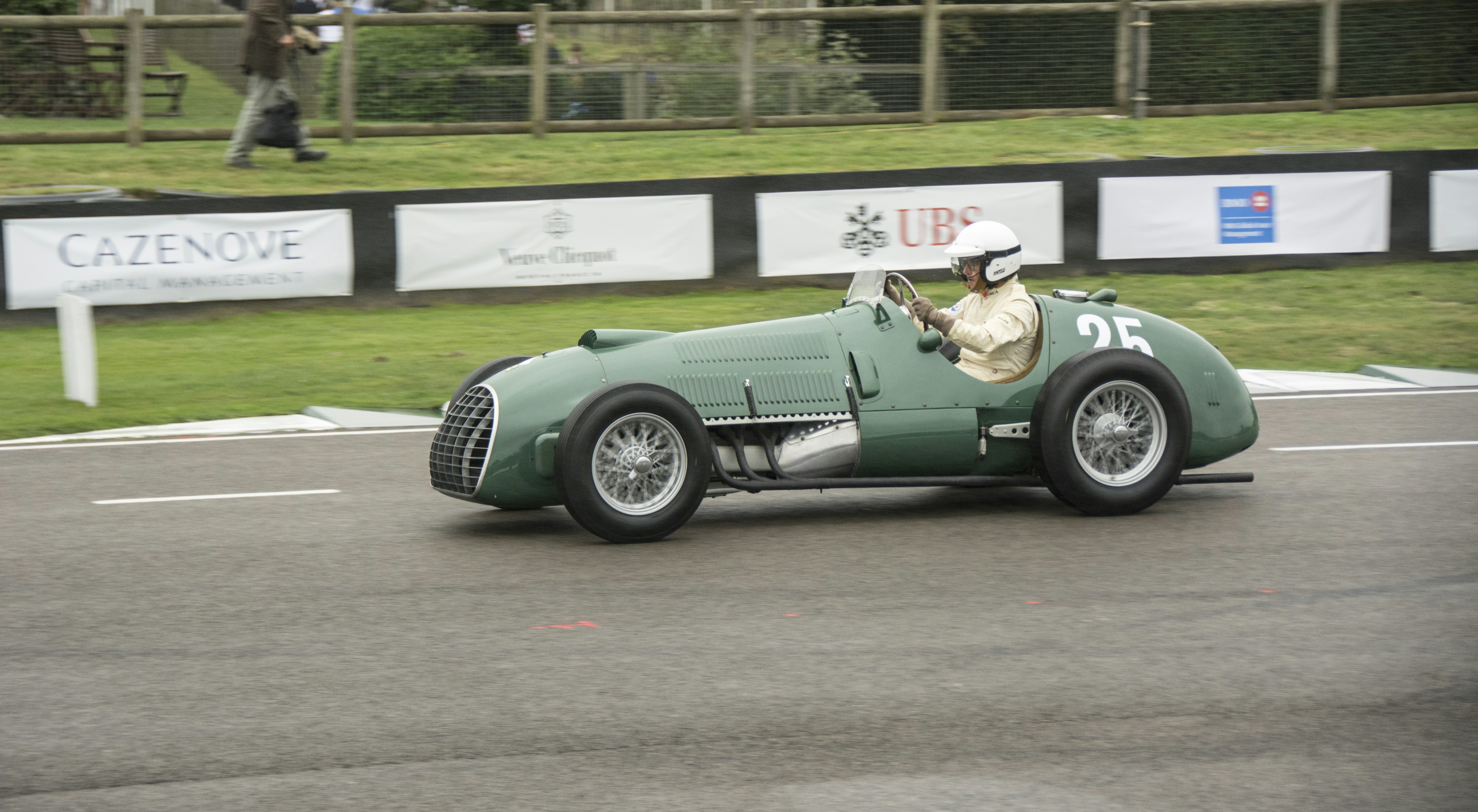 A man driving a green race car down a street photo – Free Chichester ...