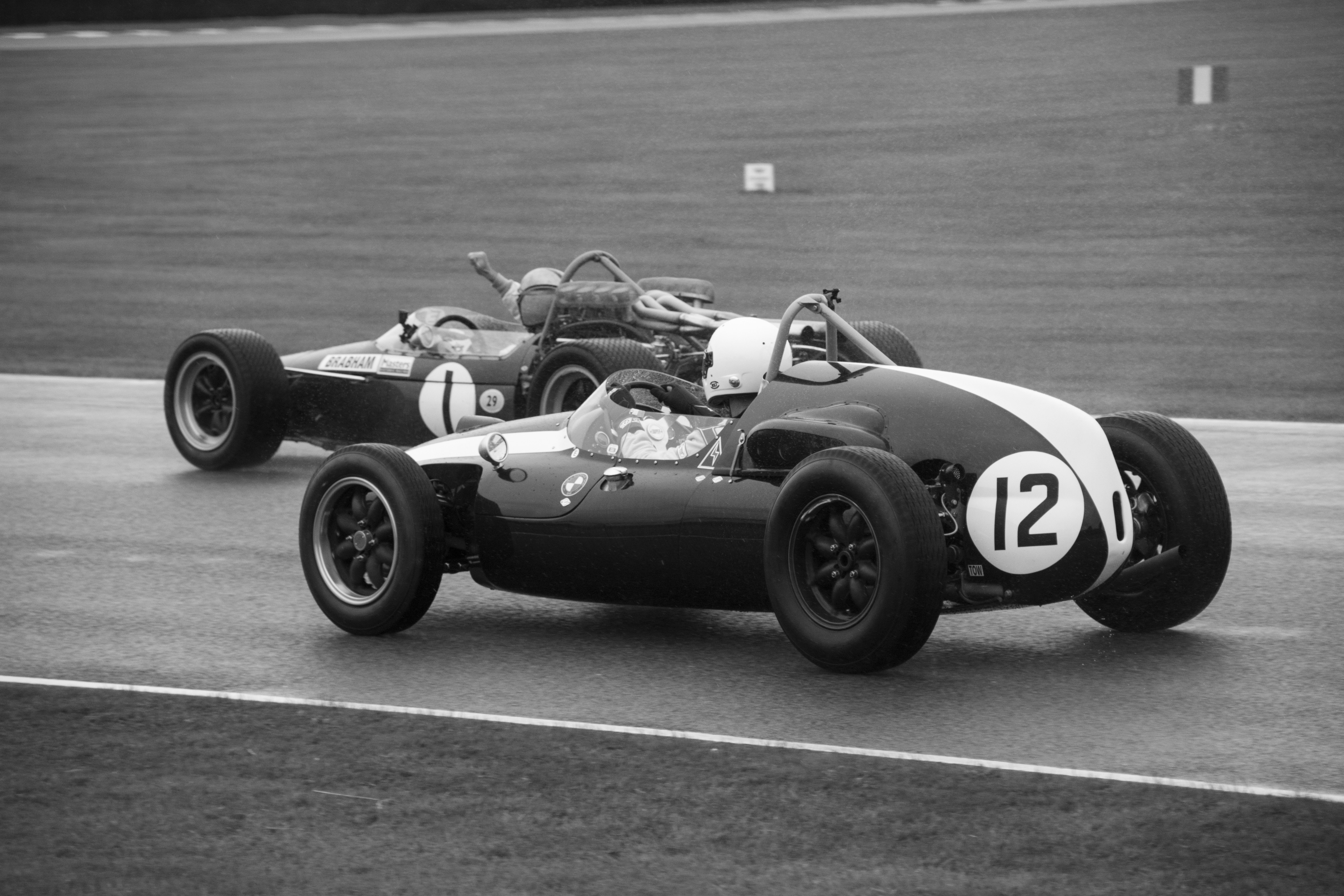 A couple of racing cars driving down a race track photo – Free Goodwood ...
