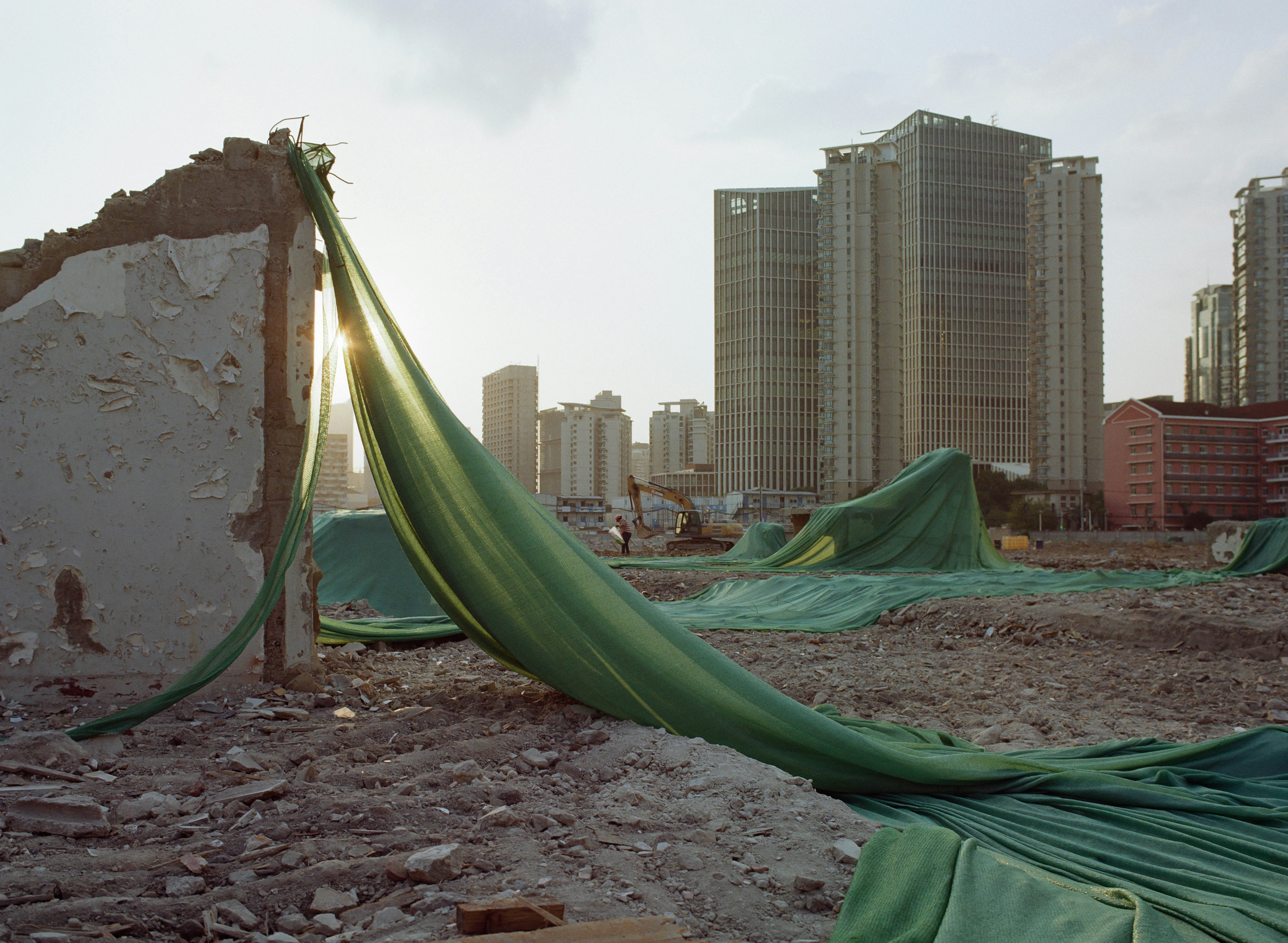 A green tarp covering a building in the middle of a city photo – Free ...