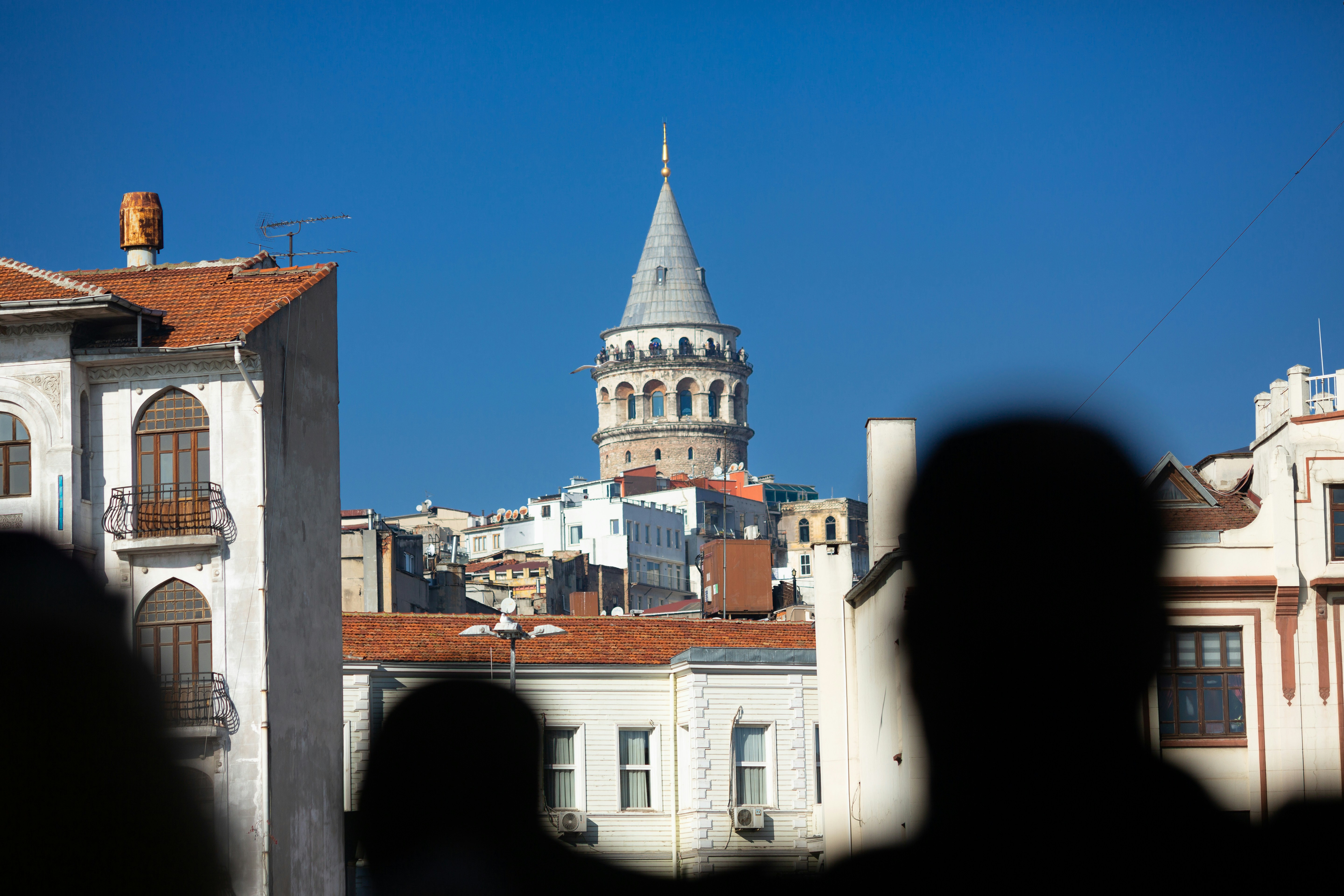 Galata Tower Emerges Over Silhouetted Rooftops Against a Clear Istanbul Sky