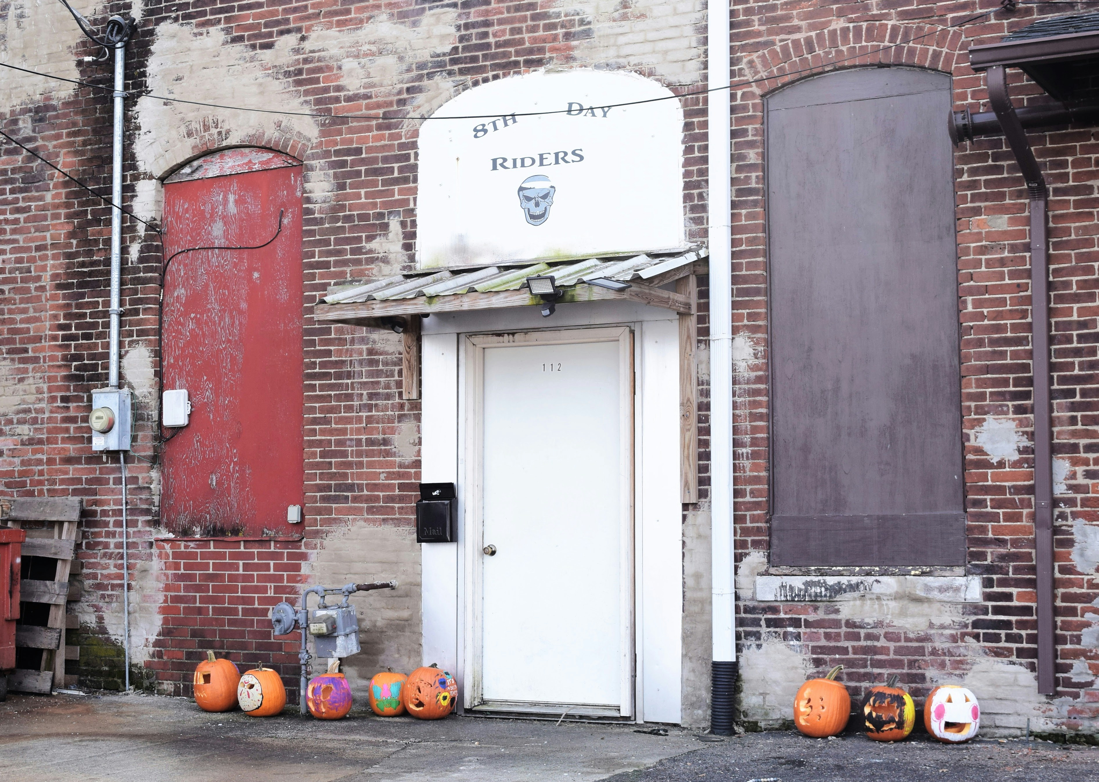 A brick building with a white door and some pumpkins photo – Free ...