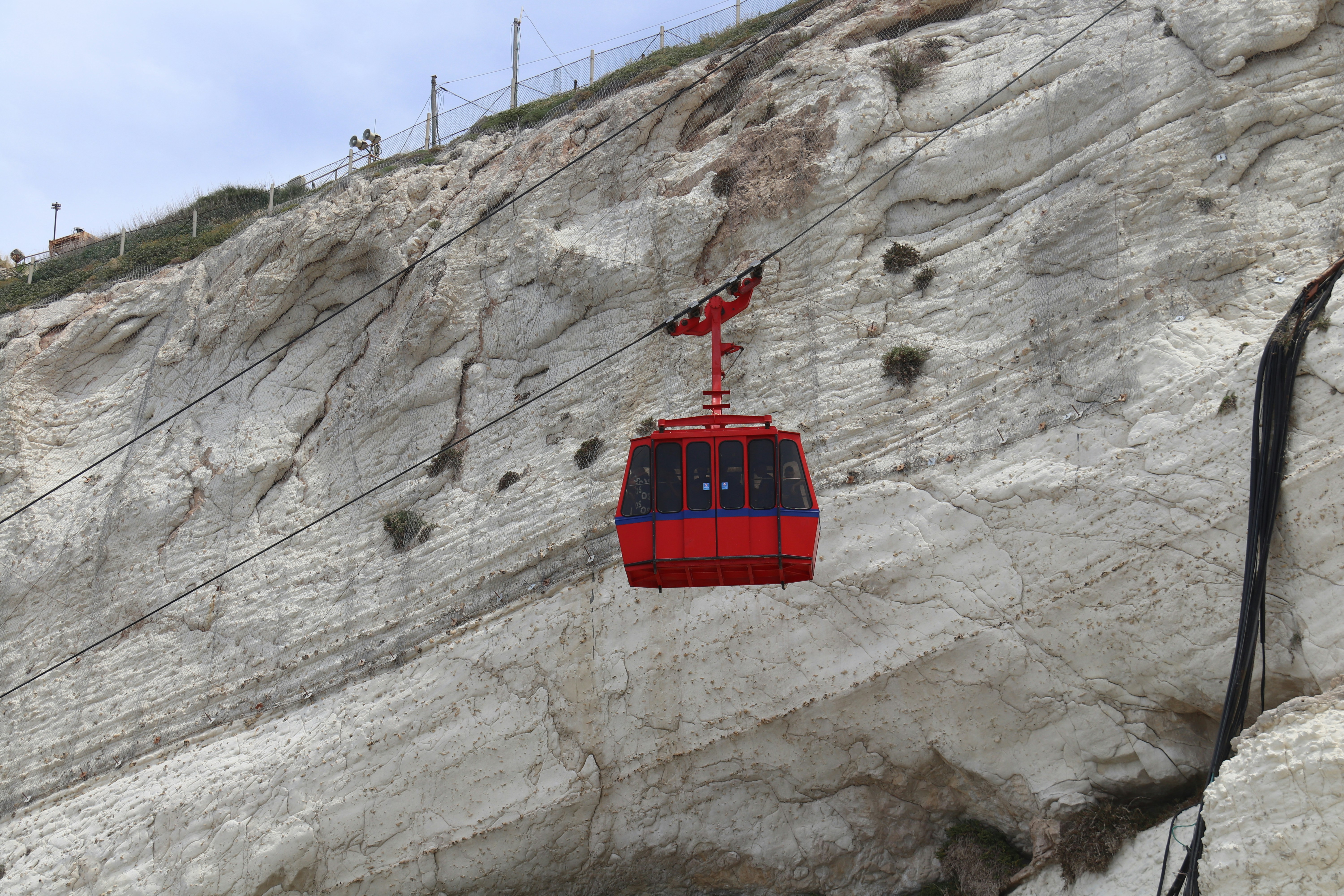 A red cable car going up a mountain side photo – Free Rosh hanikra ...