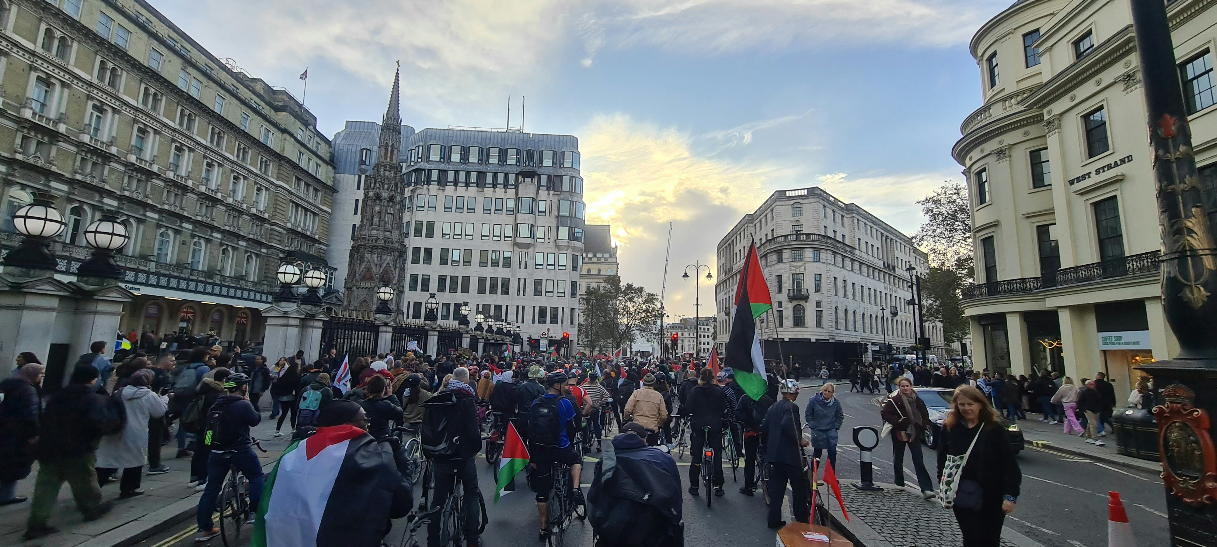 A crowd of people walking down a street next to tall buildings photo ...