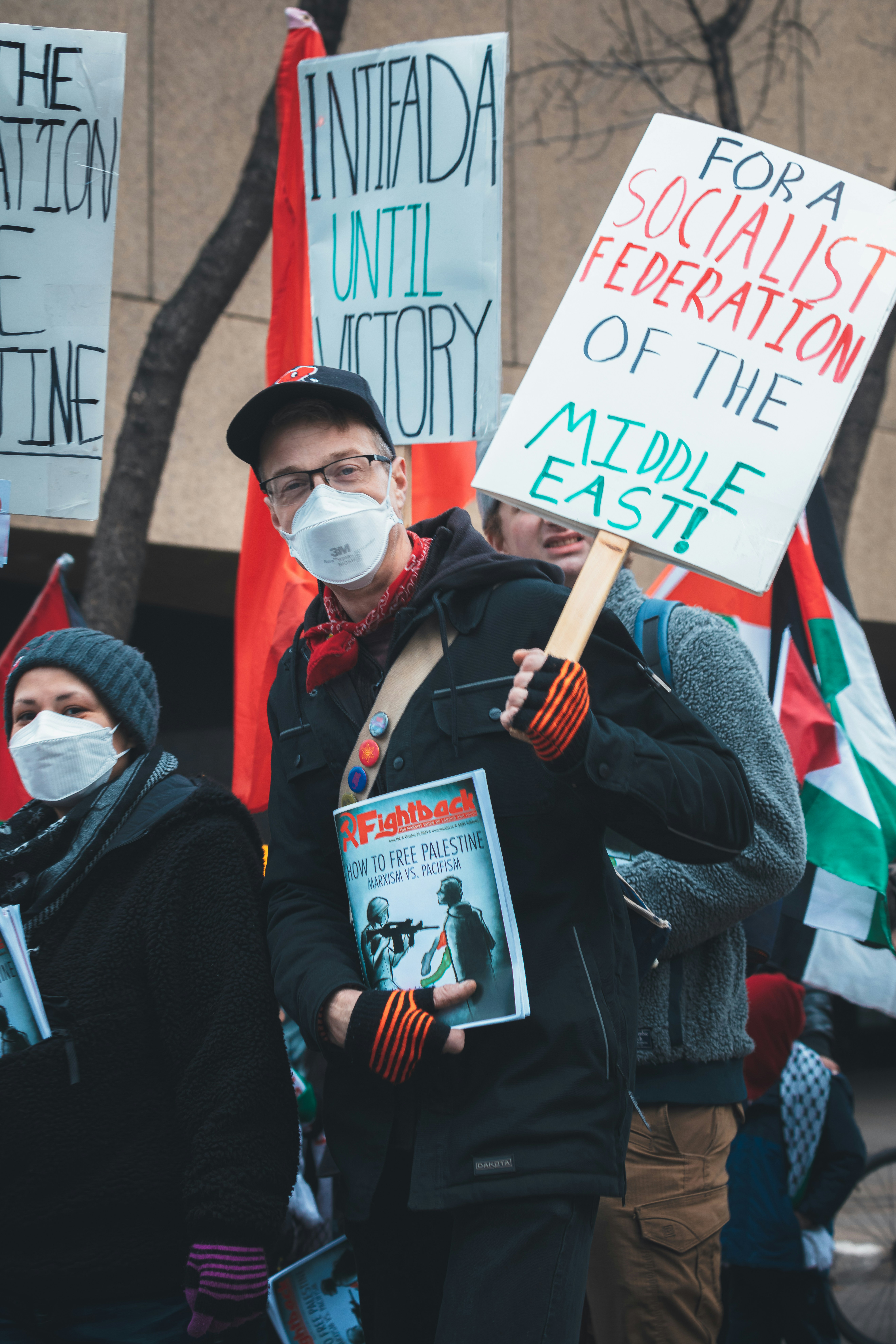 A group of people holding protest signs in front of a building photo ...
