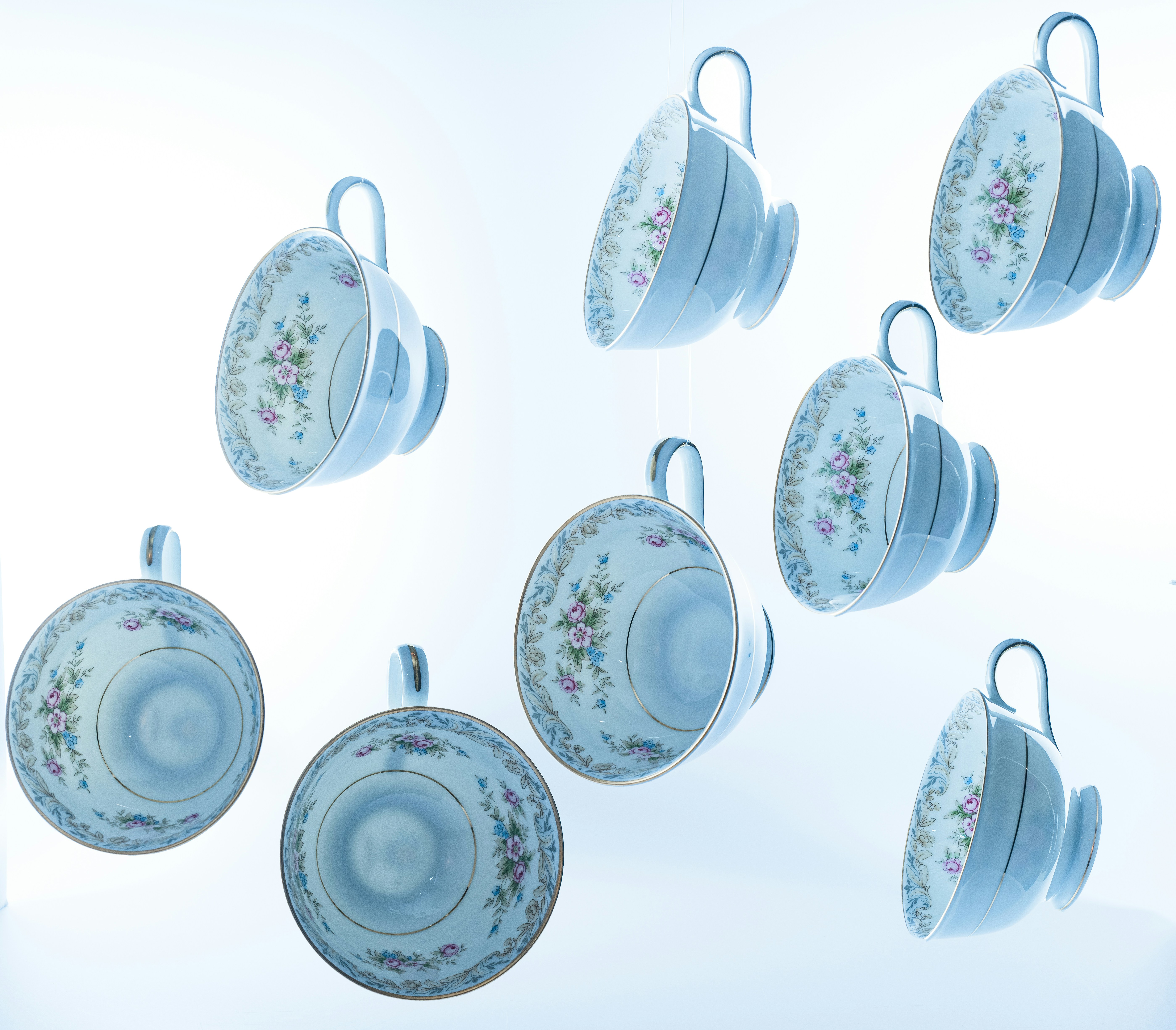 A group of tea cups and saucers hanging from hooks photo – Free Magic ...