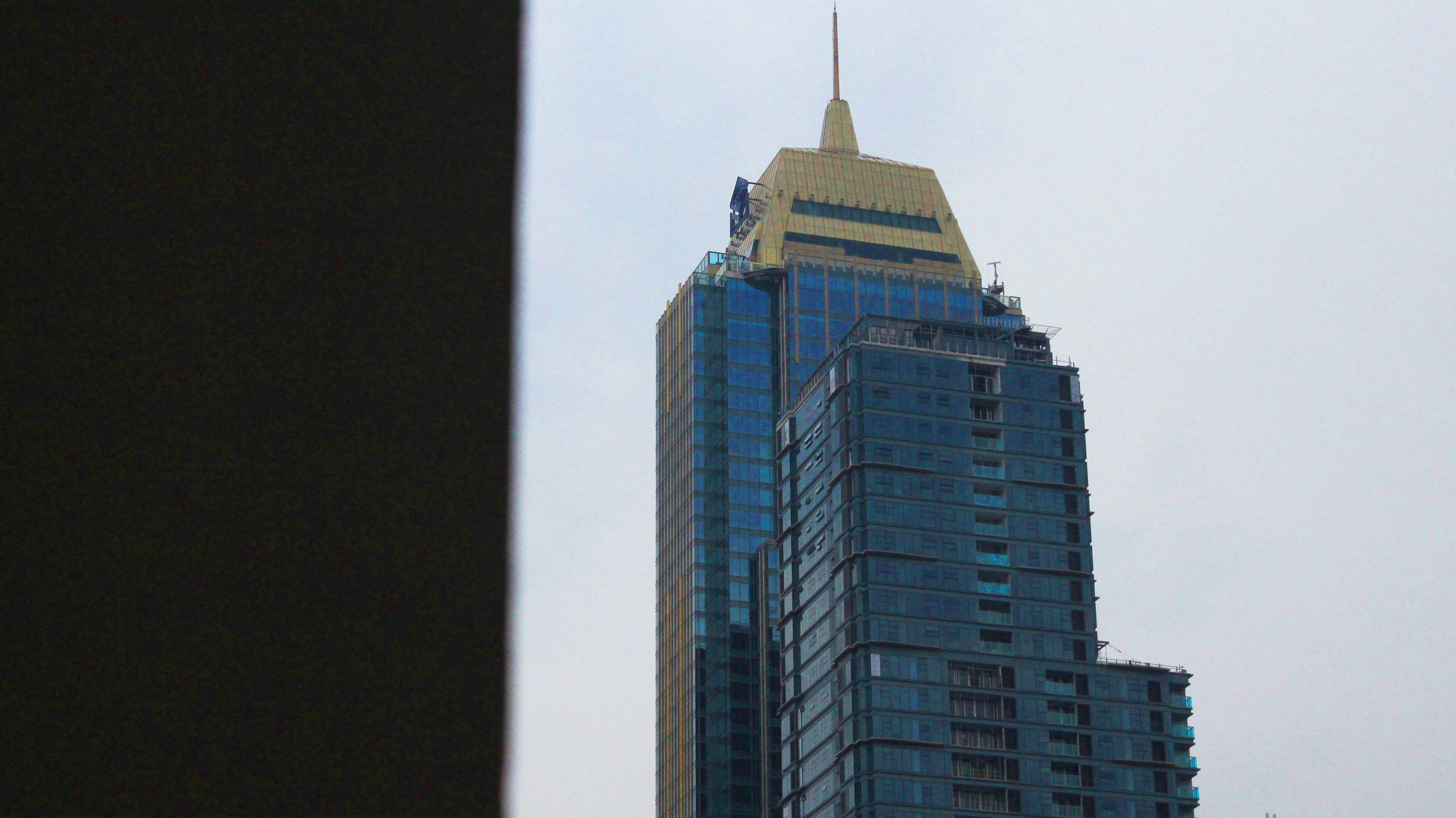 Spire-Topped Glass Tower Reaches Into a Clear Sky