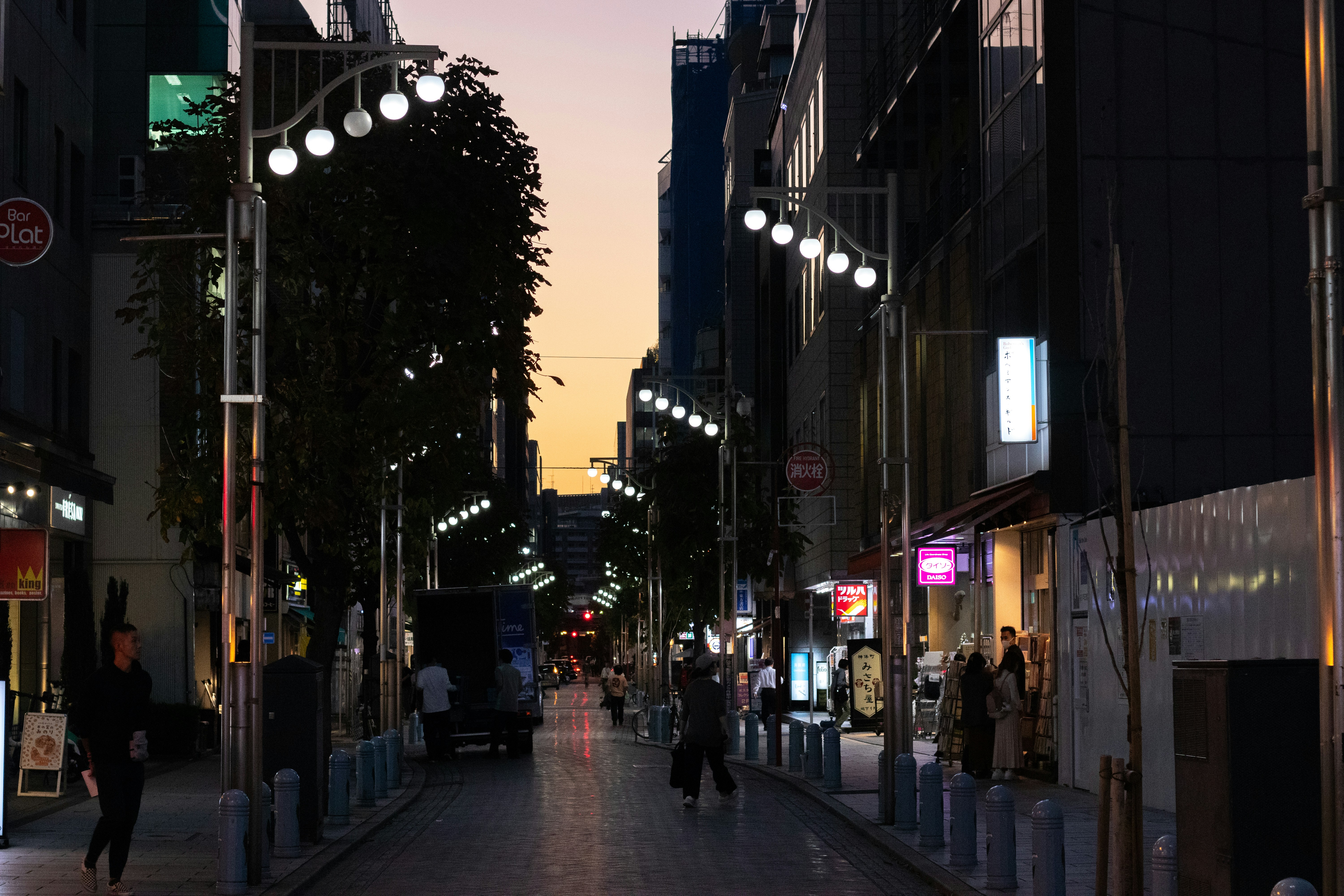 A city street at night with people walking on the sidewalk photo – Free ...