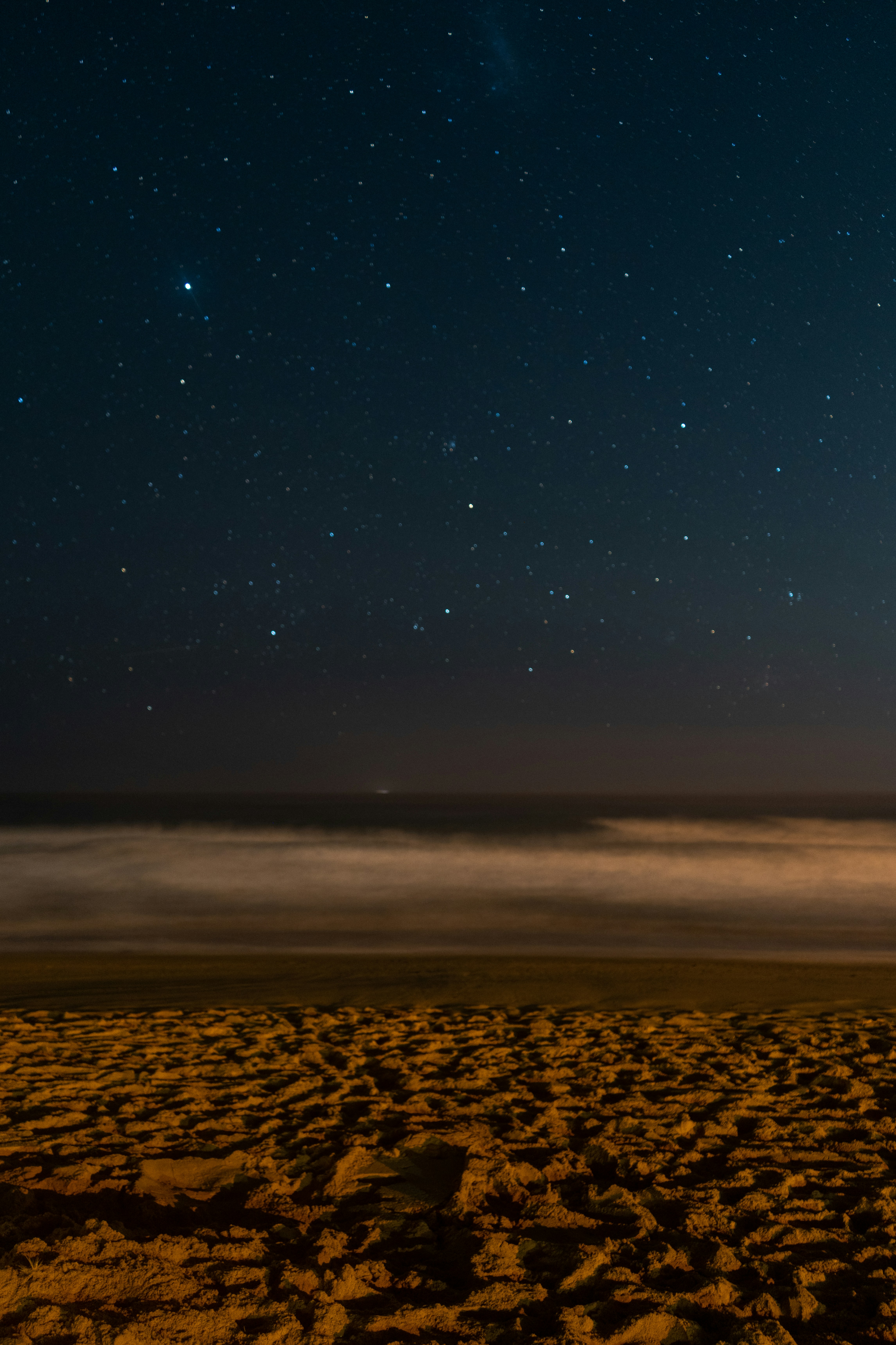 Ember-Touched Shore Beneath a Star-Speckled Sky