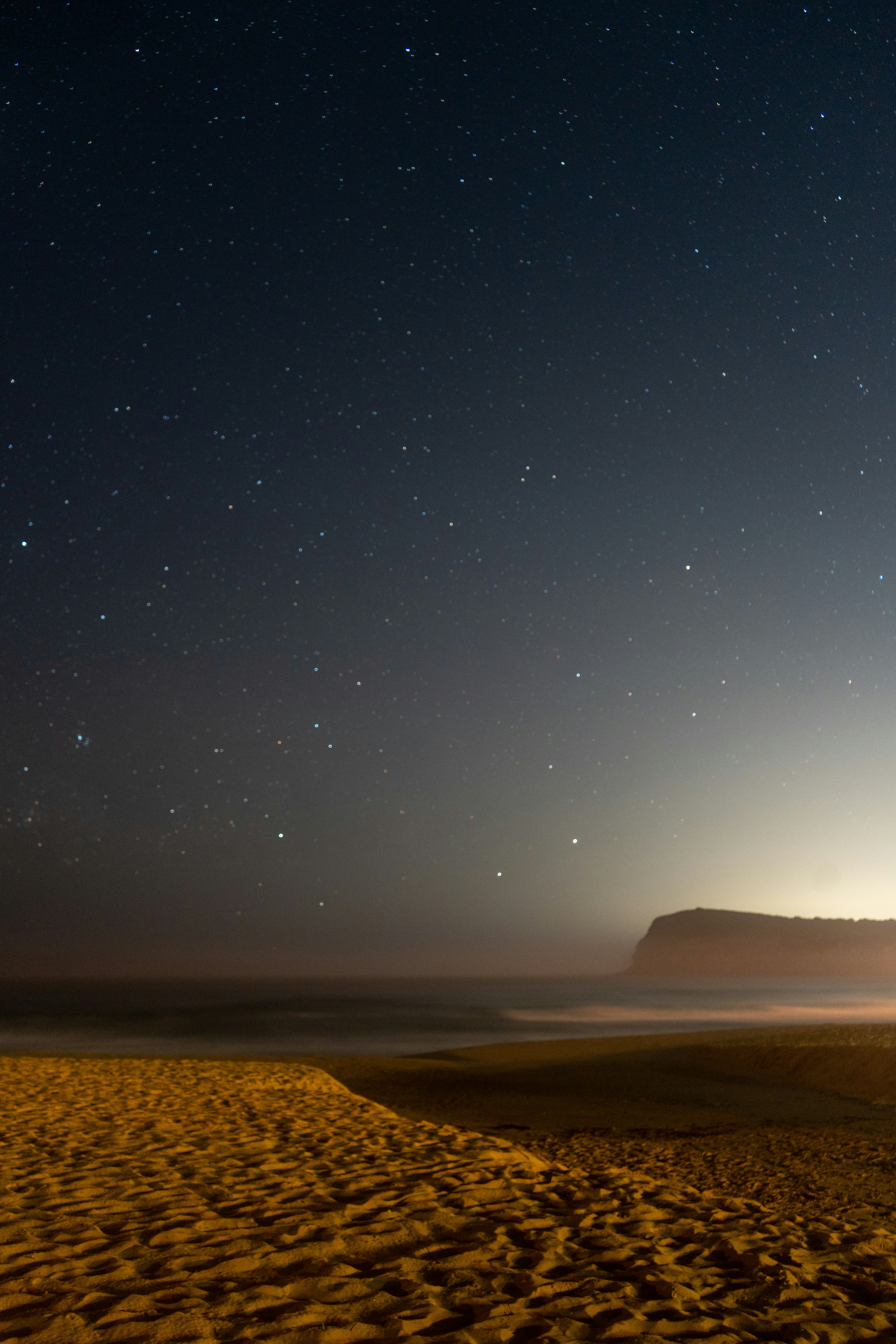 A night sky with stars above a beach photo – Free Ocean Image on Unsplash