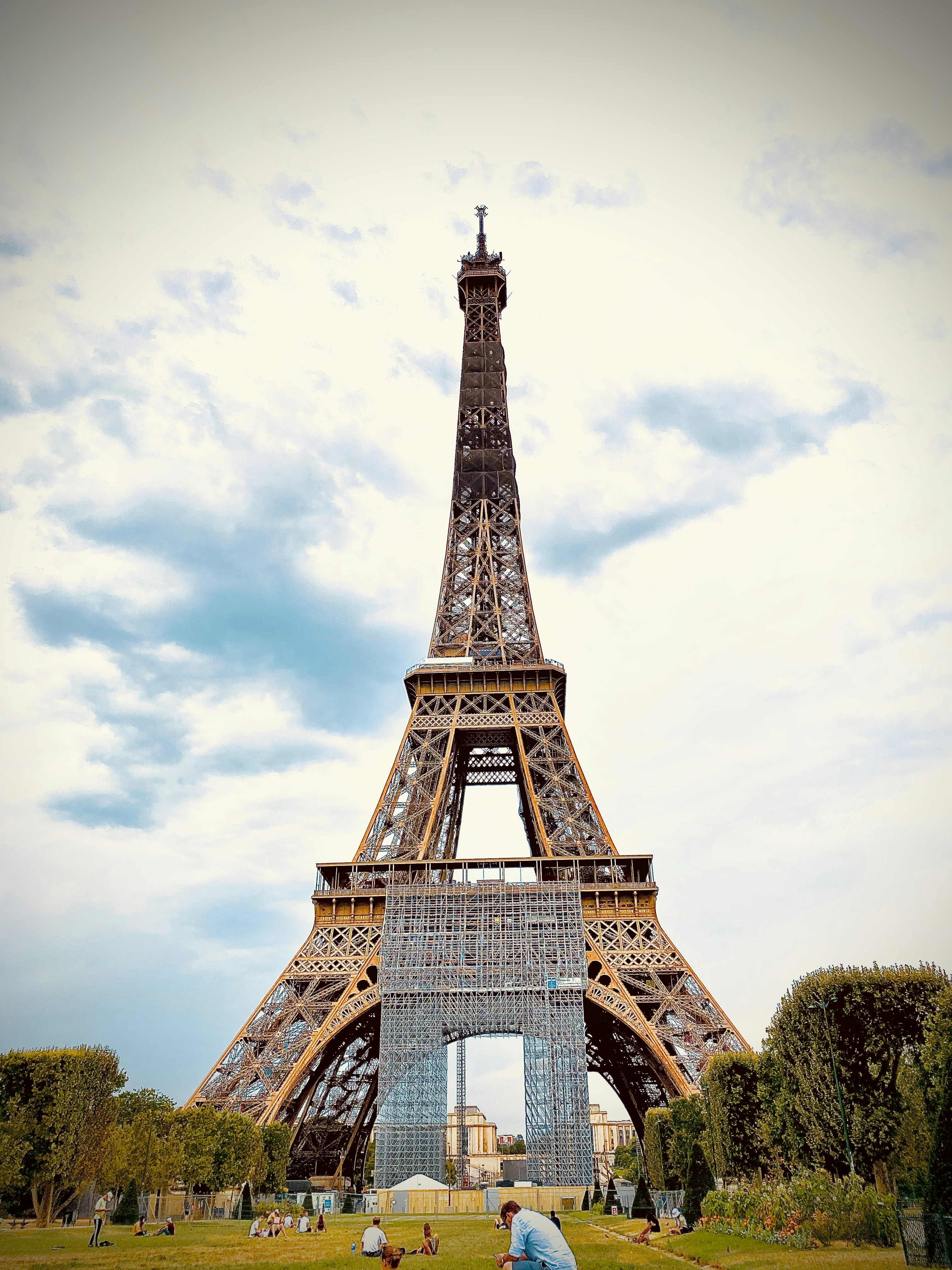 A person sitting on a bench in front of the eiffel tower photo – Free ...