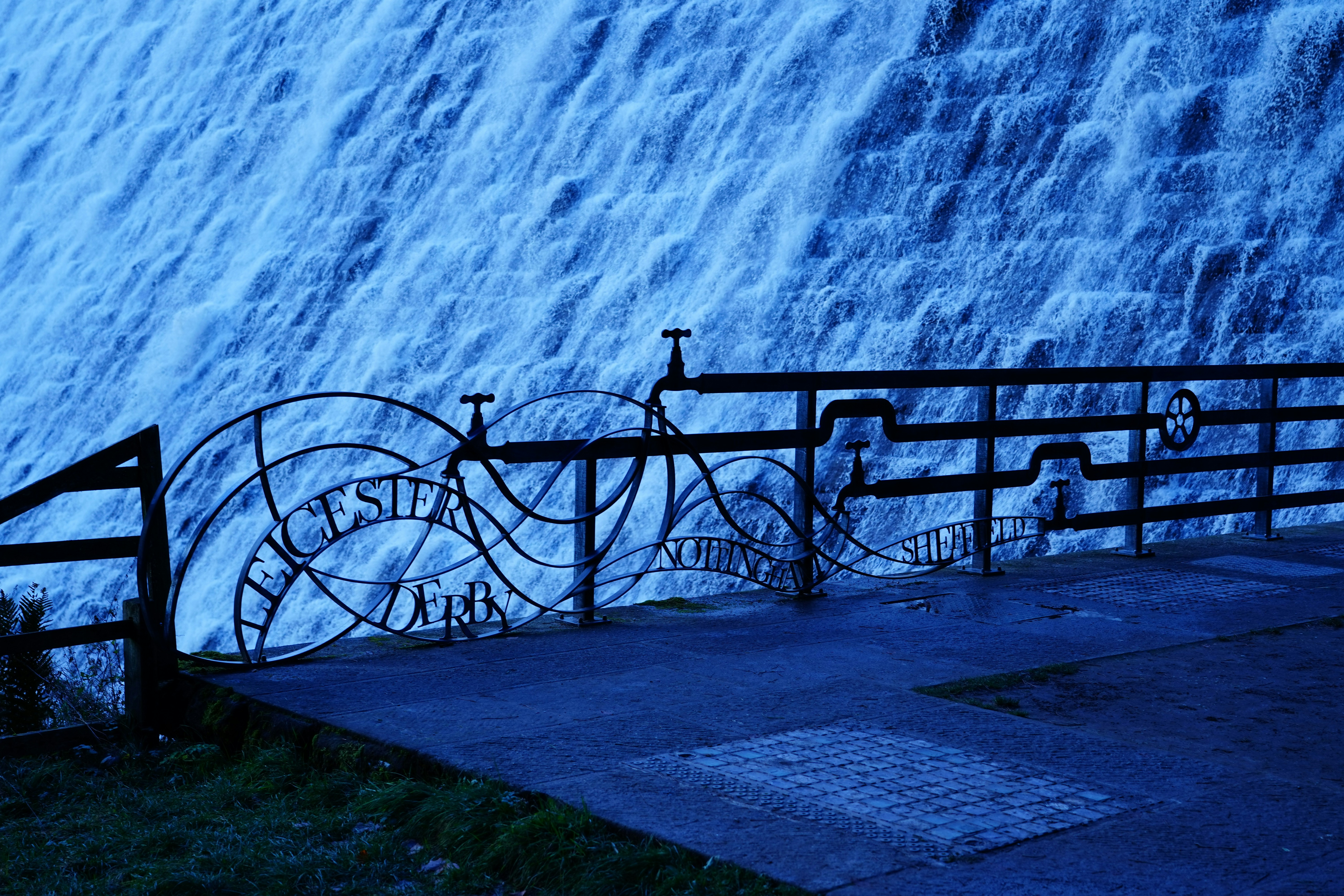 Lone Figure on a Cobalt Cascade: Riverside Railings at Dusk