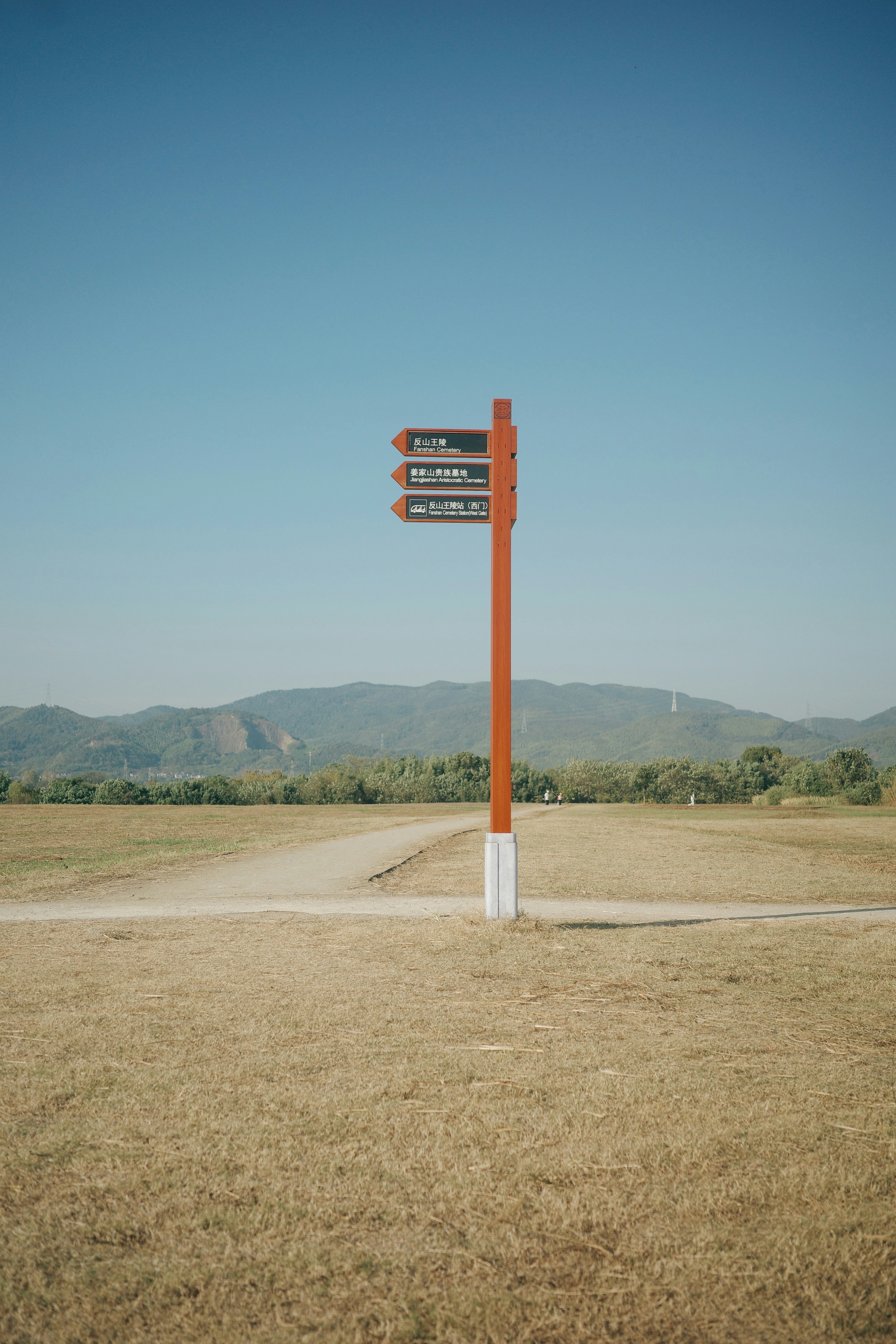 A street sign in a field with mountains in the background photo – Free ...