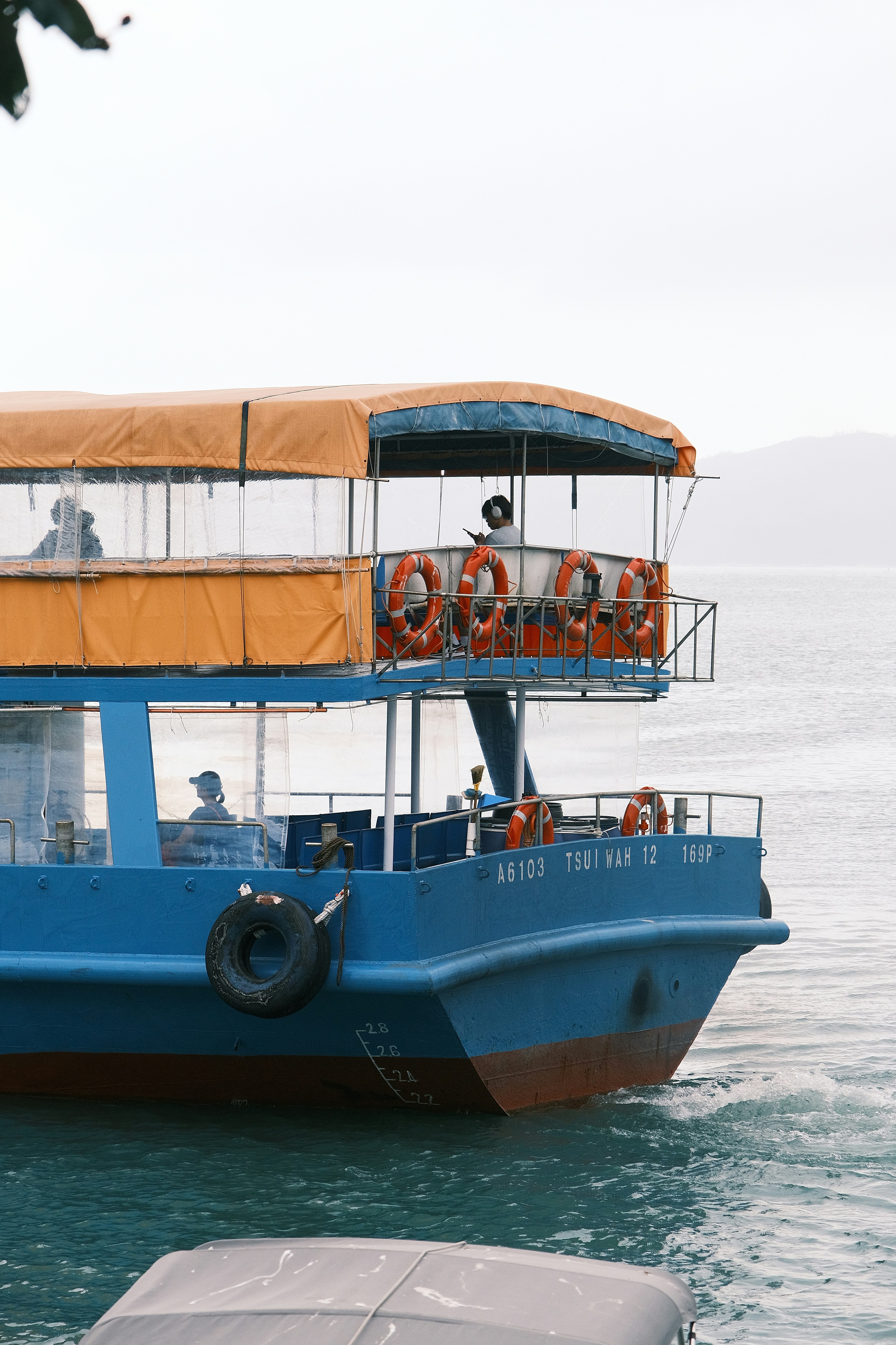 Color-Blocked Ferry: Blue Hull and Orange Canopy Against Calm Sea