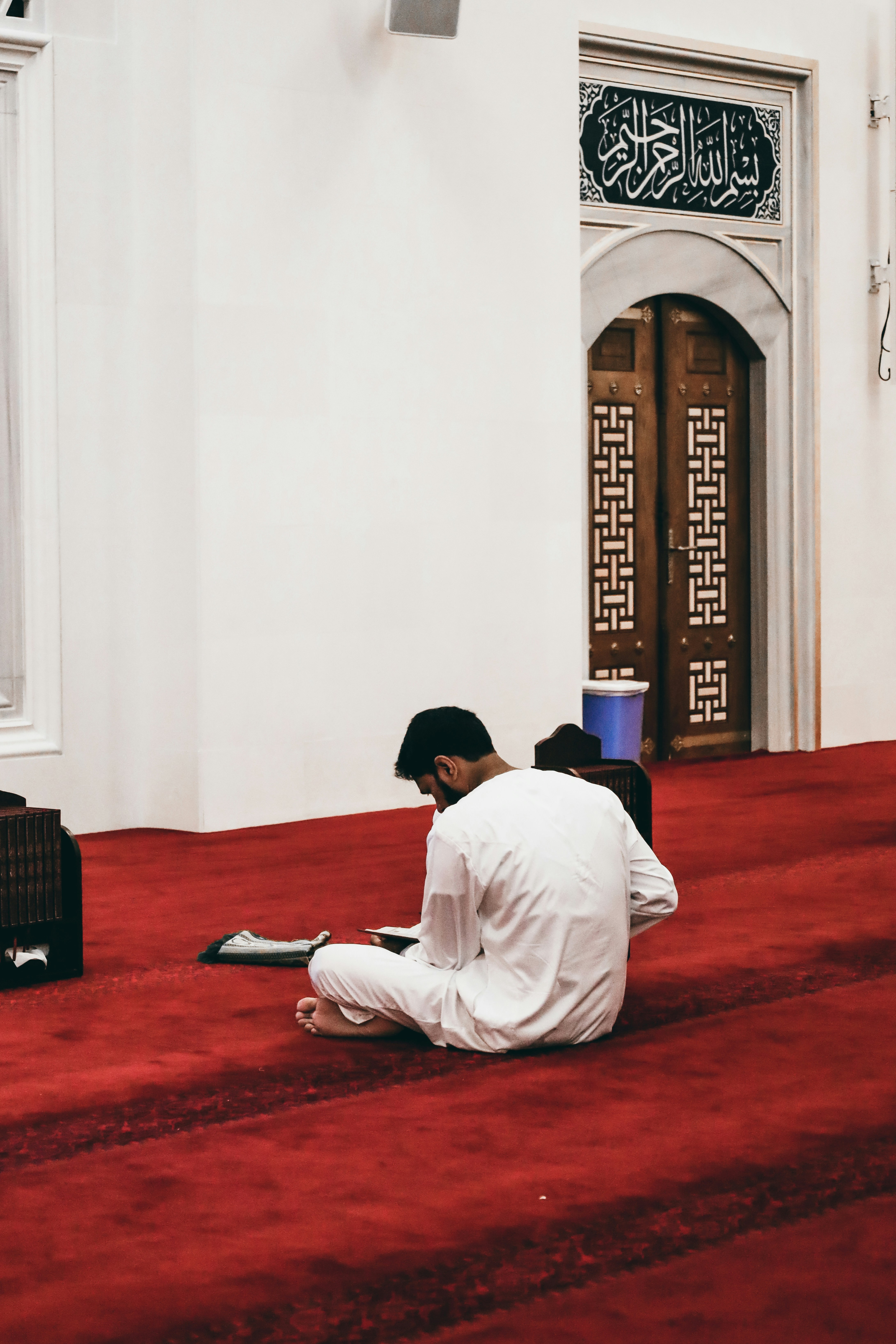 Quiet Contemplation on a Crimson Carpet by Ornate Doors