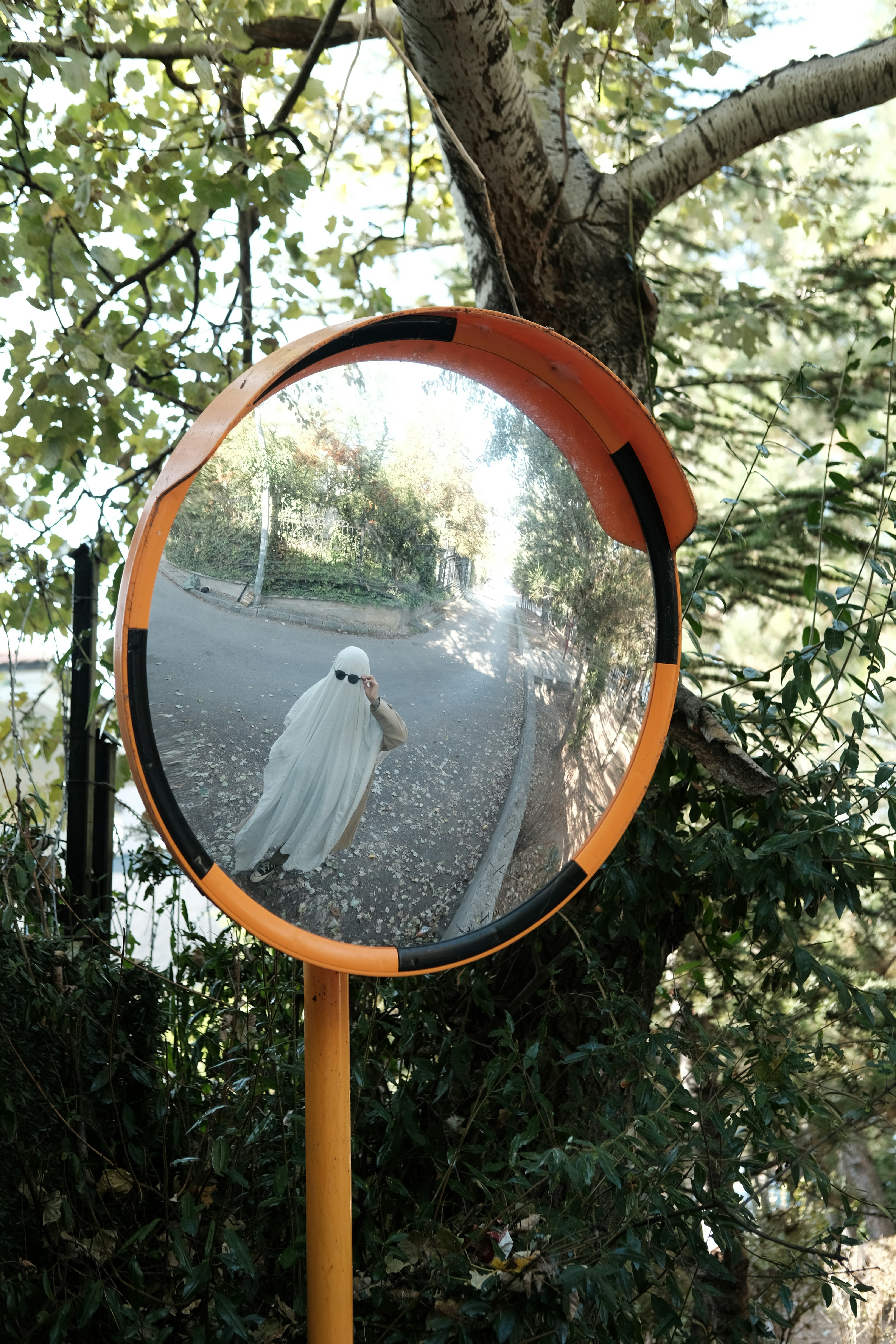 Orange Ring Mirror Portrait: A veiled figure reflected on a sunlit path