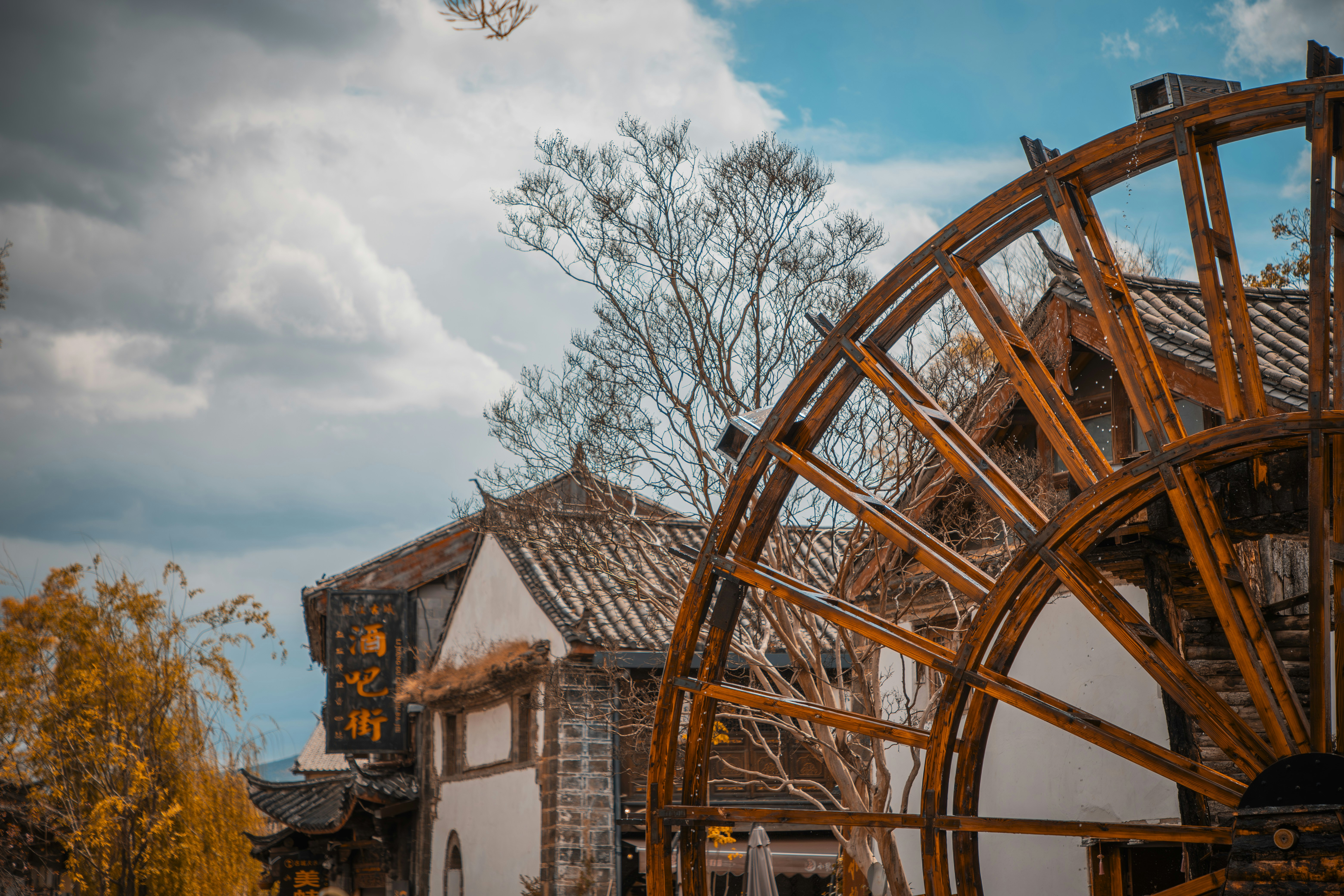Circular Echo: A Timber Waterwheel Framed by Autumn Light