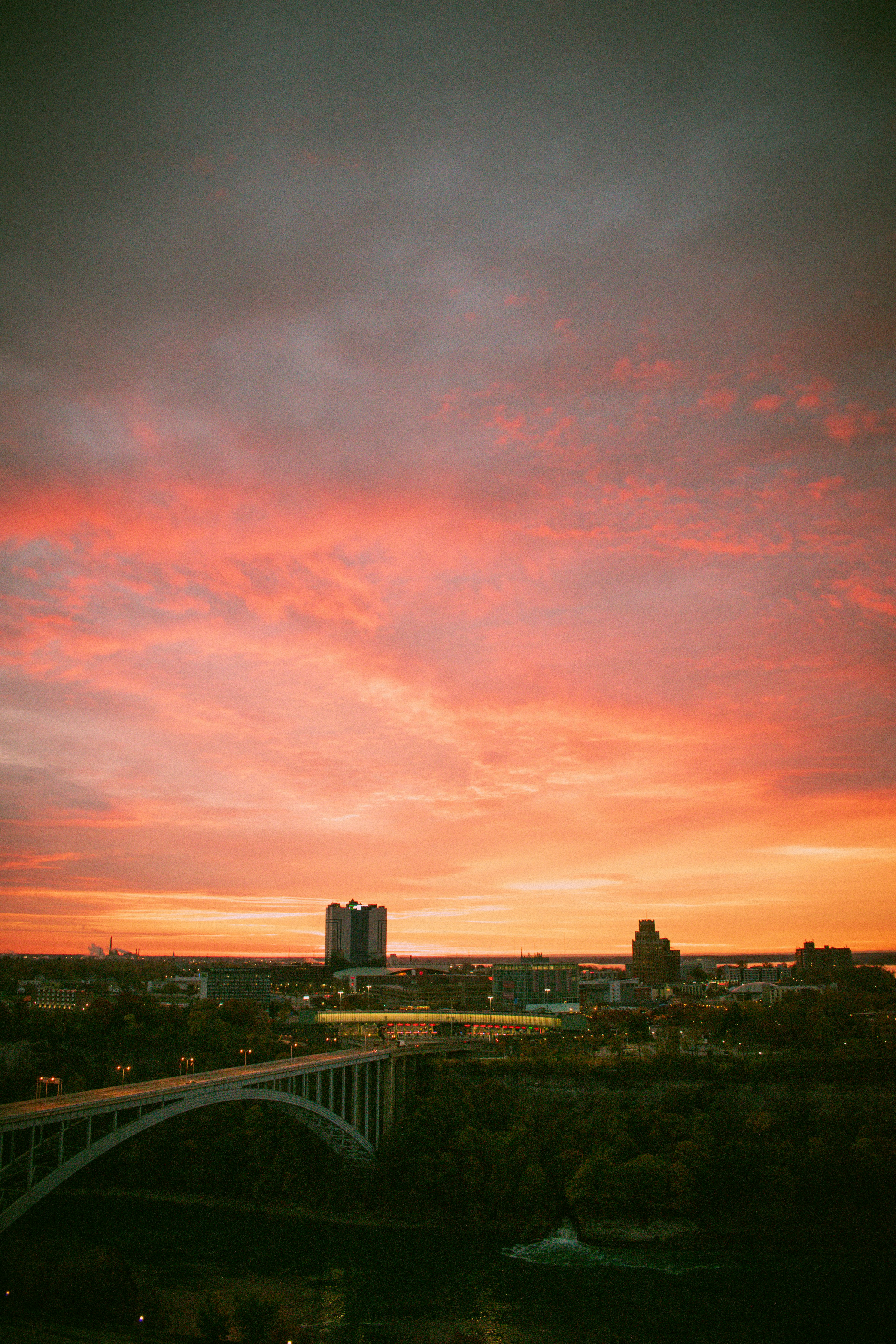 Crimson Horizon over the River: Urban Silhouette Framed by an Arc Bridge