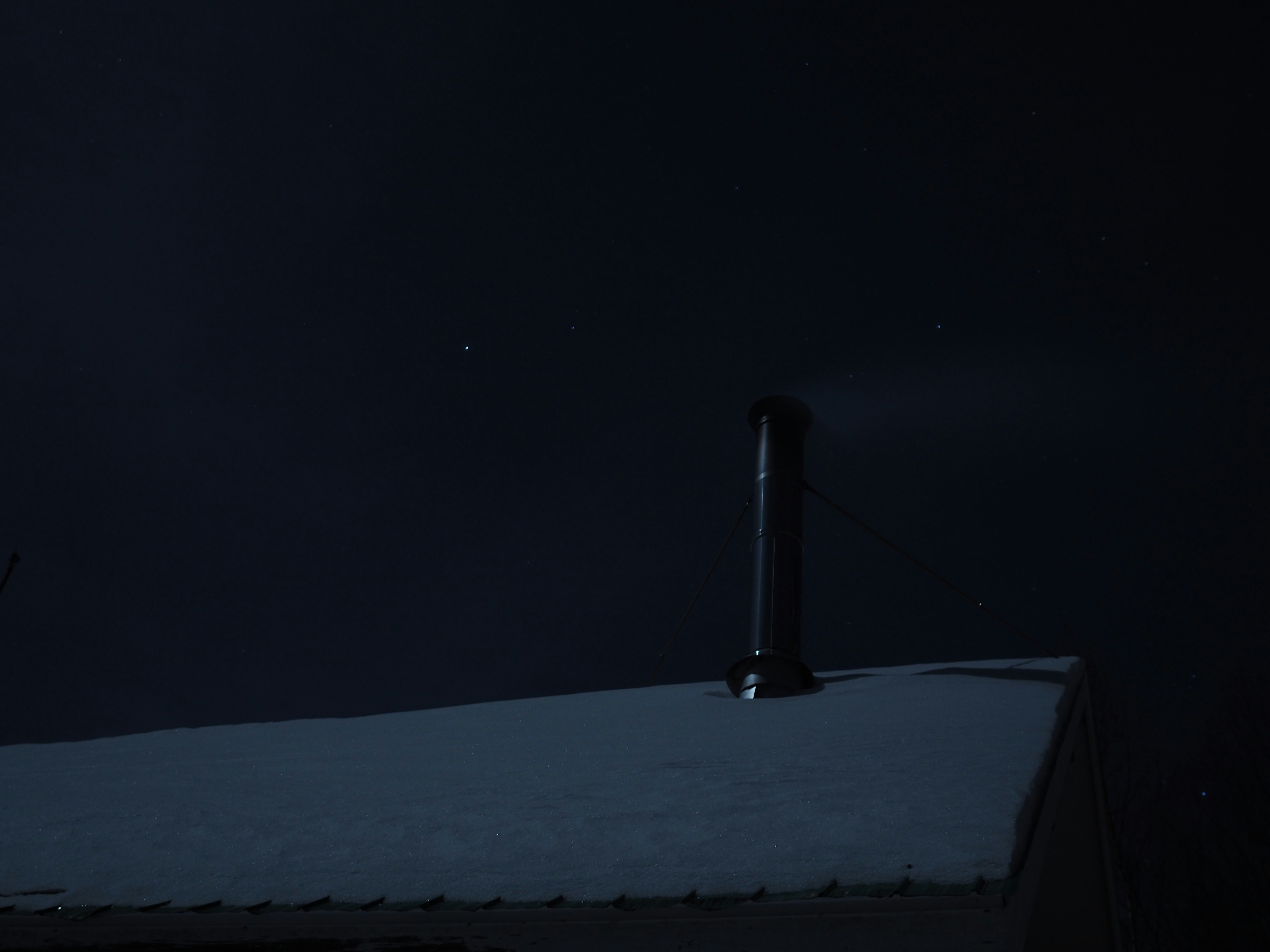 Midnight Chimney Over a Snow-Covered Roof Beneath Starry Sky