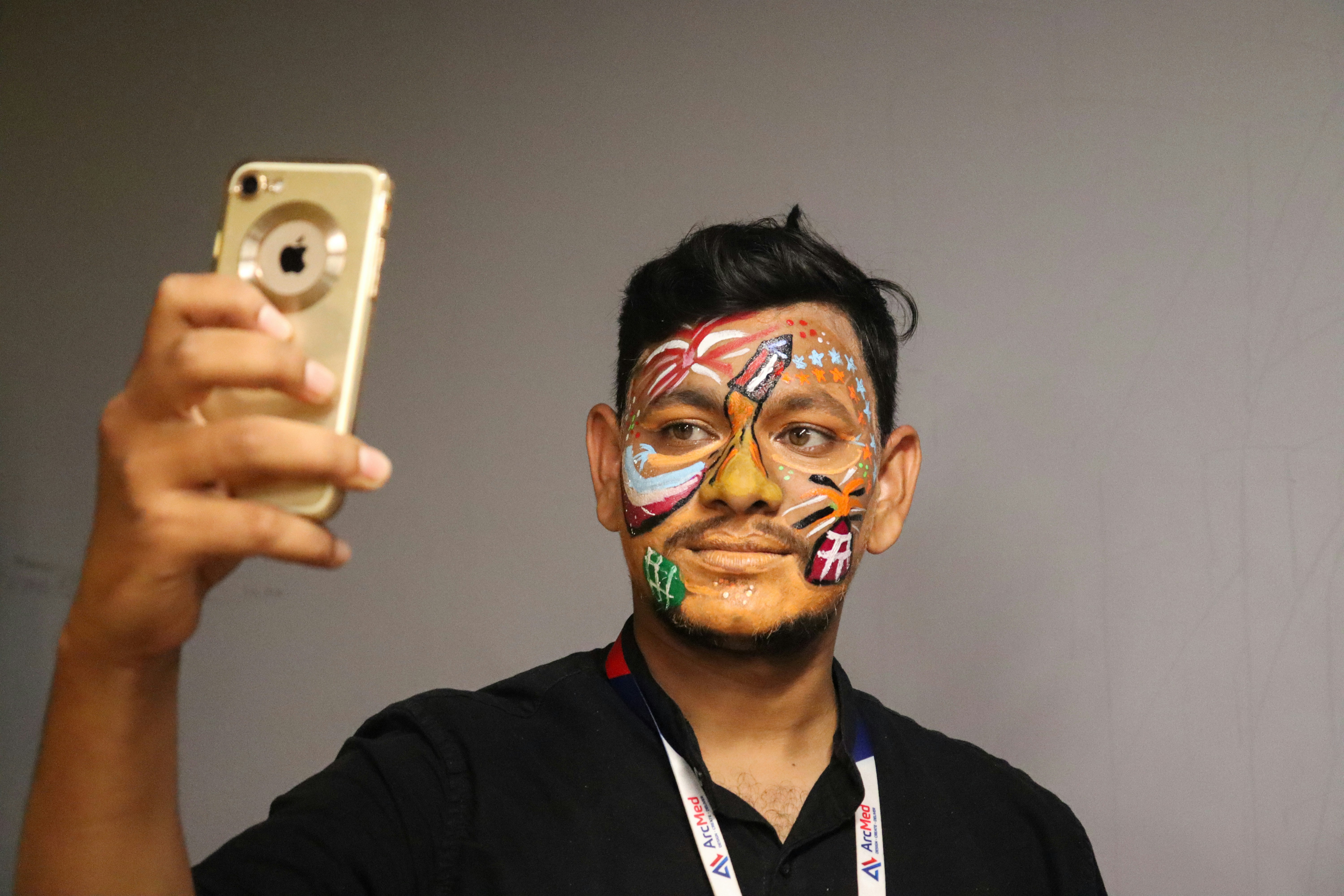 Face-painted Selfie in a Studio: A Colorful Portrait in Front of a Plain Backdrop