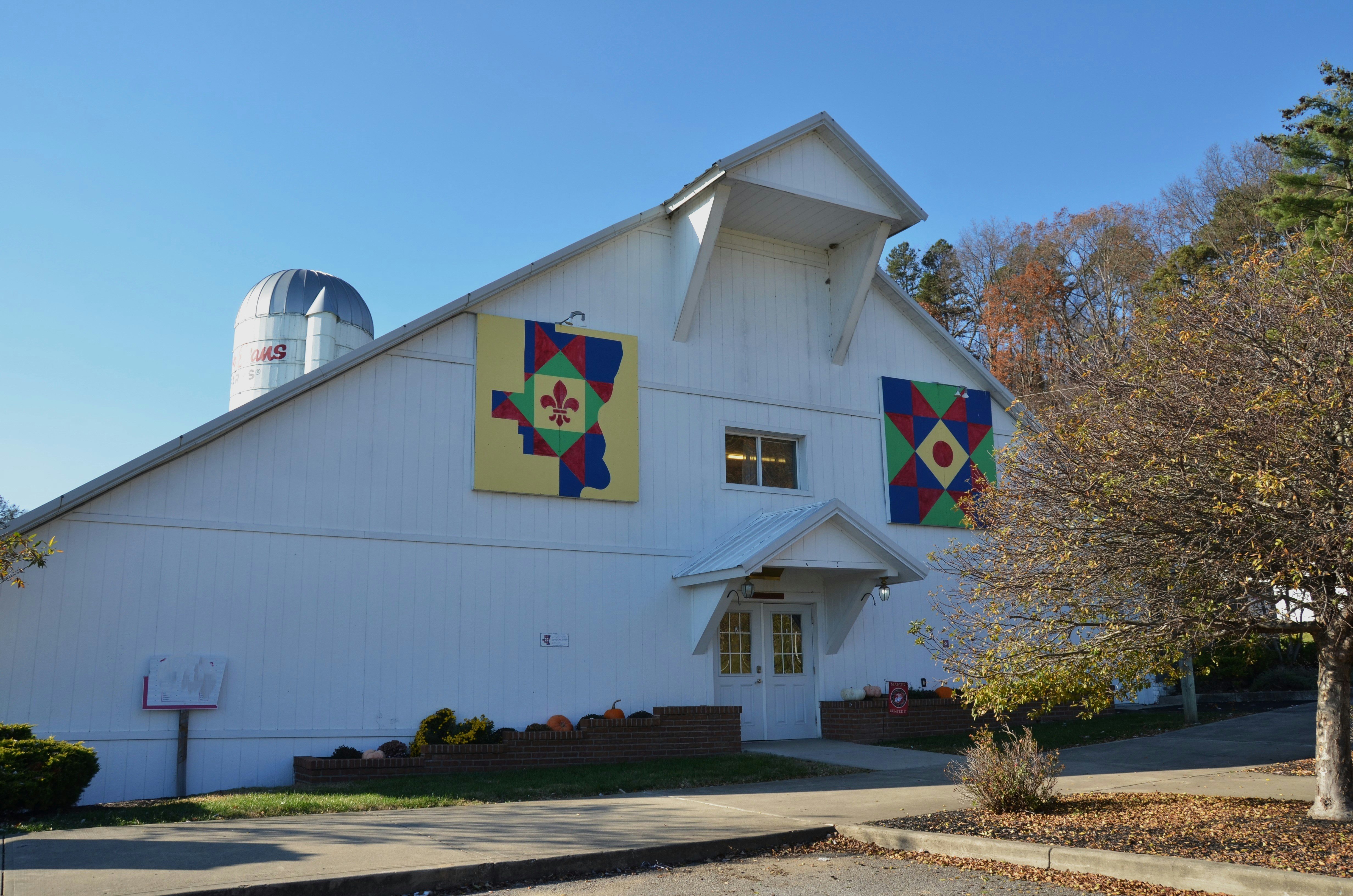 A large white barn with quilts on the side of it photo – Free Building ...