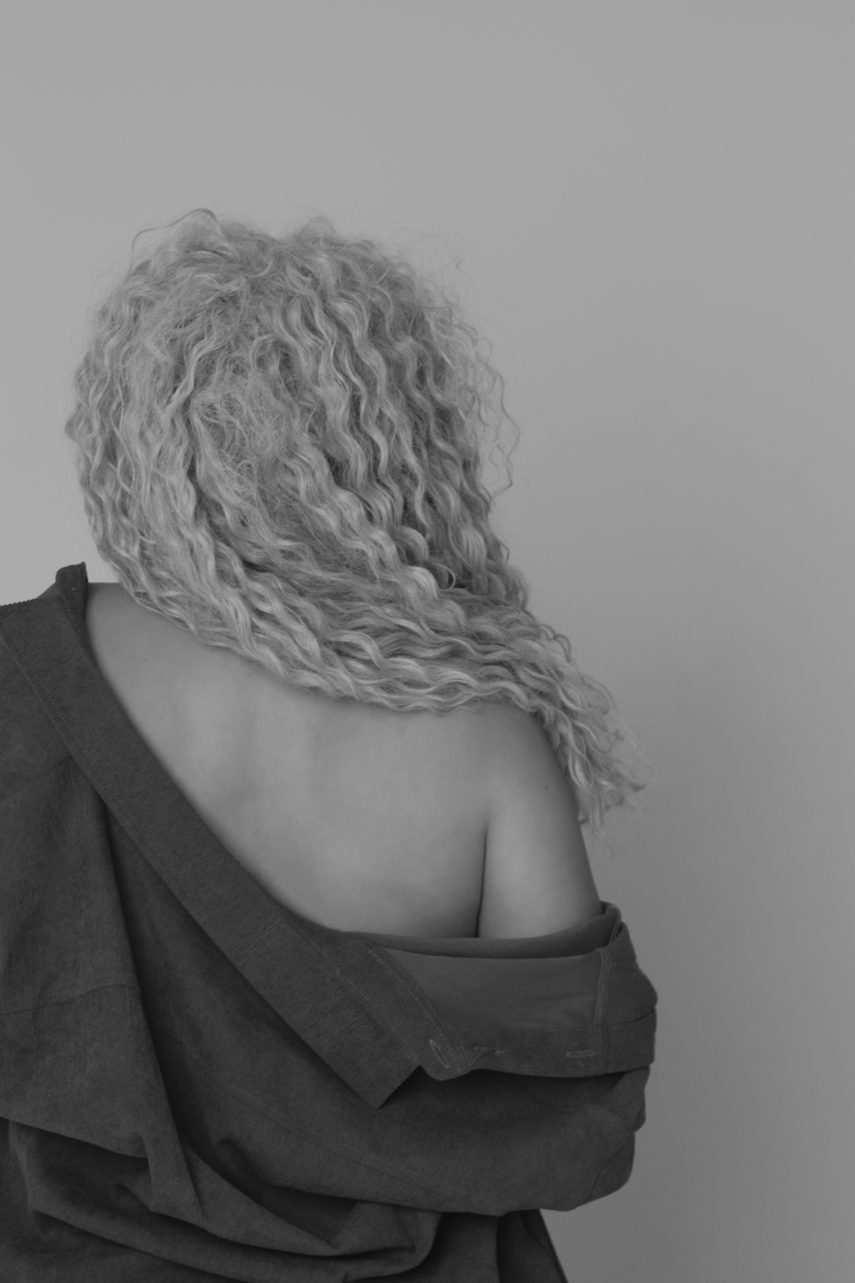 Backlit Curl Portrait: The Silent Veil of Hair and Shoulder