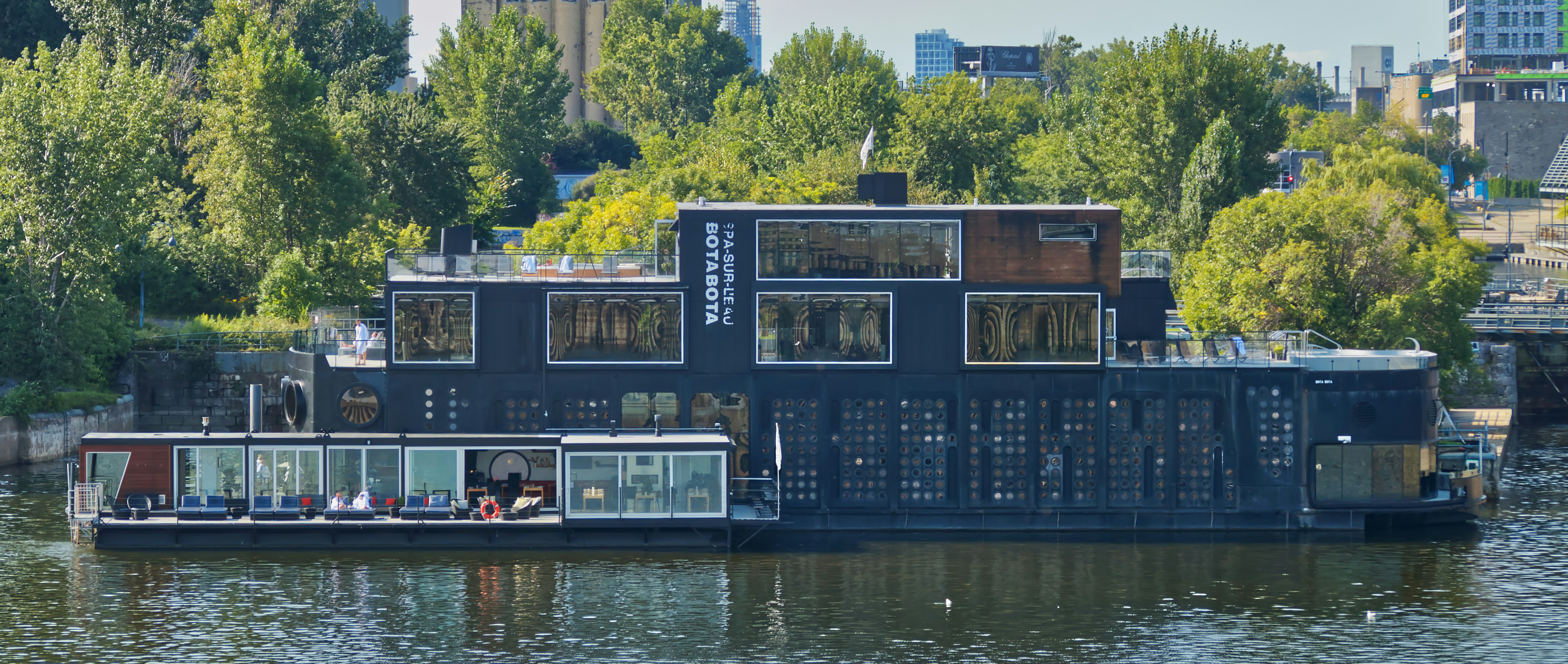 Floating Modernity: A Multi-Tiered Houseboat Lounging on Calm River Waters